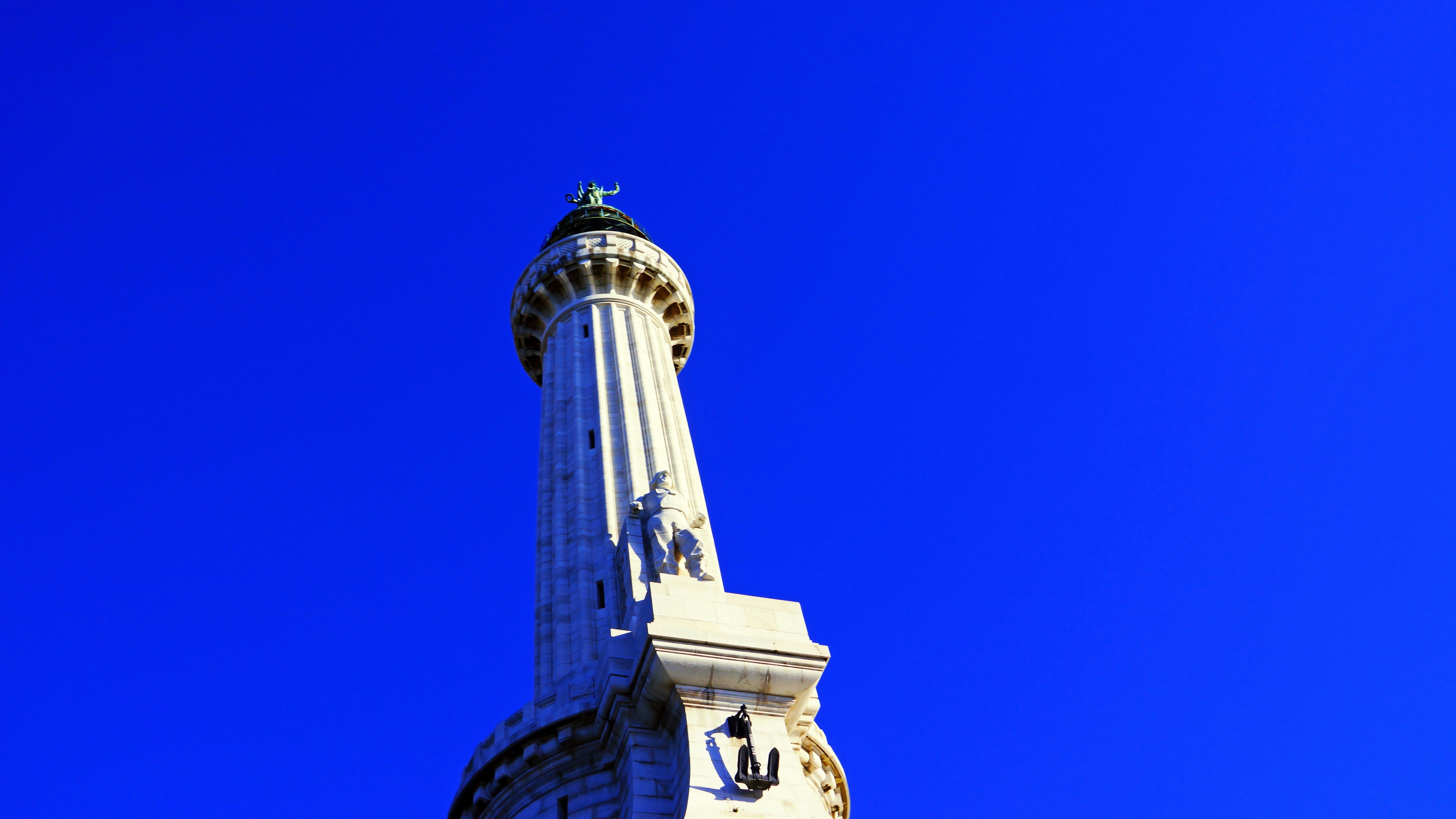 Tall white lighthouse against a bright blue sky