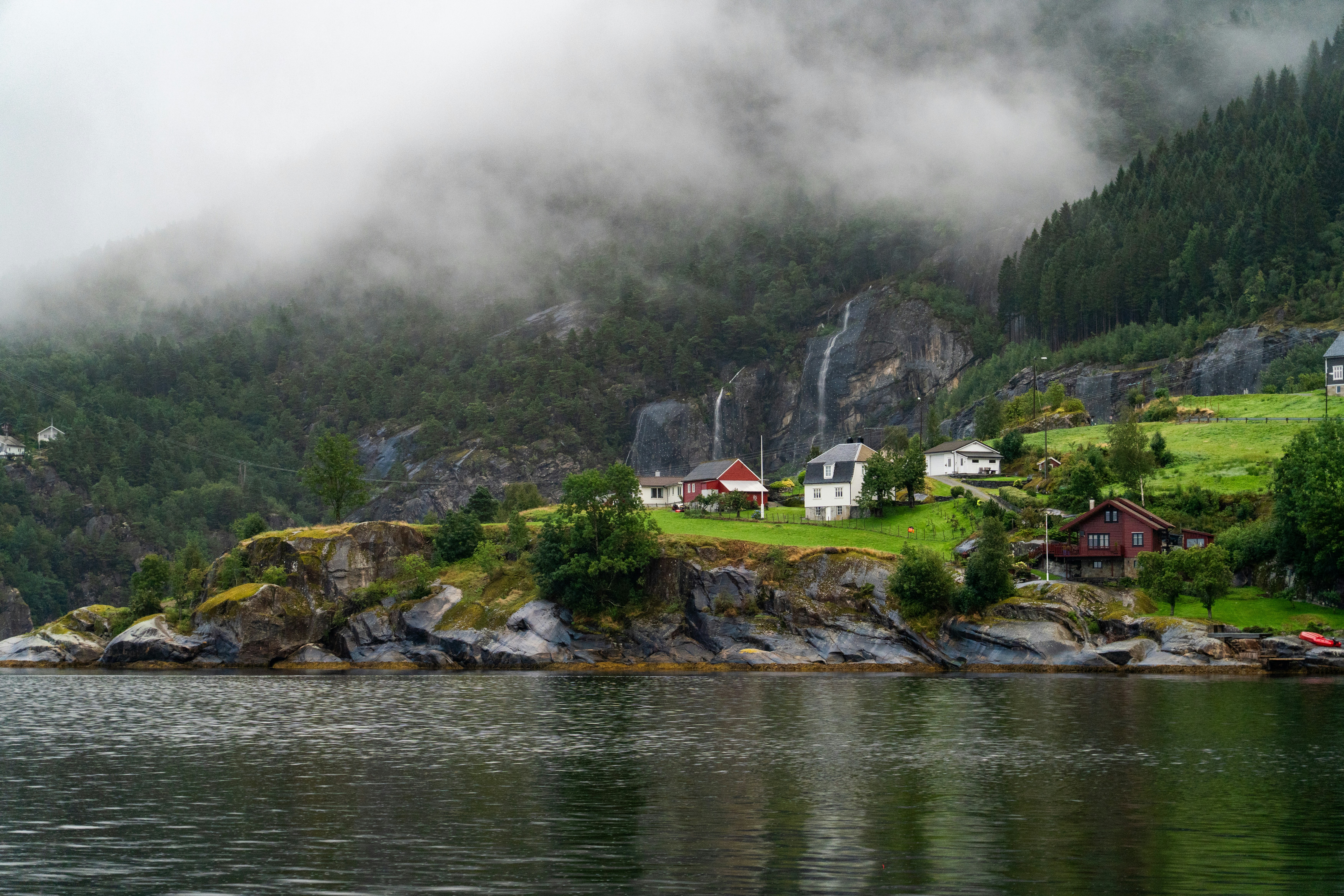 Coastal village nestled beside a misty fjord and mountains