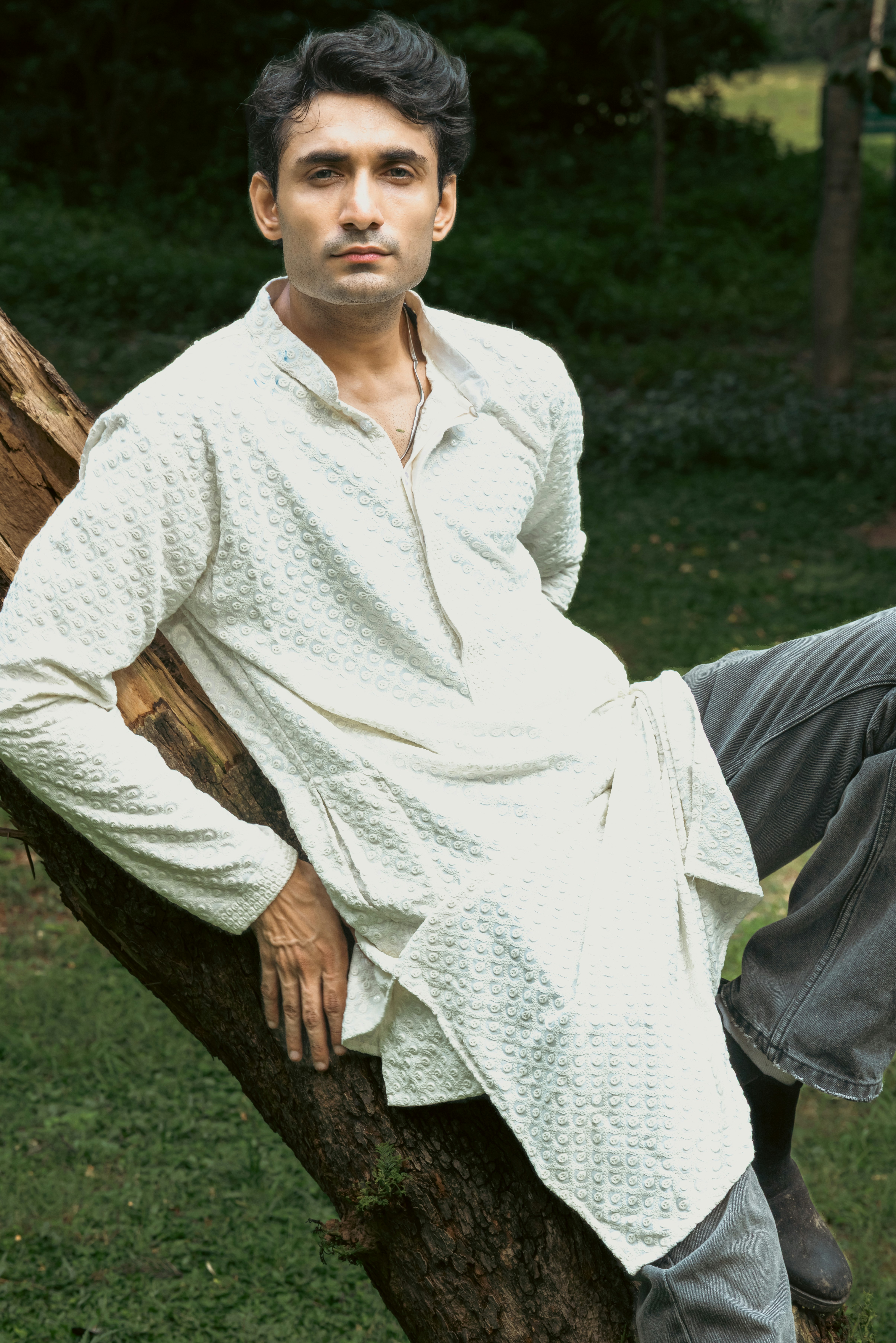Athlete of repose: man reclines on a fallen tree in a sunlit forest