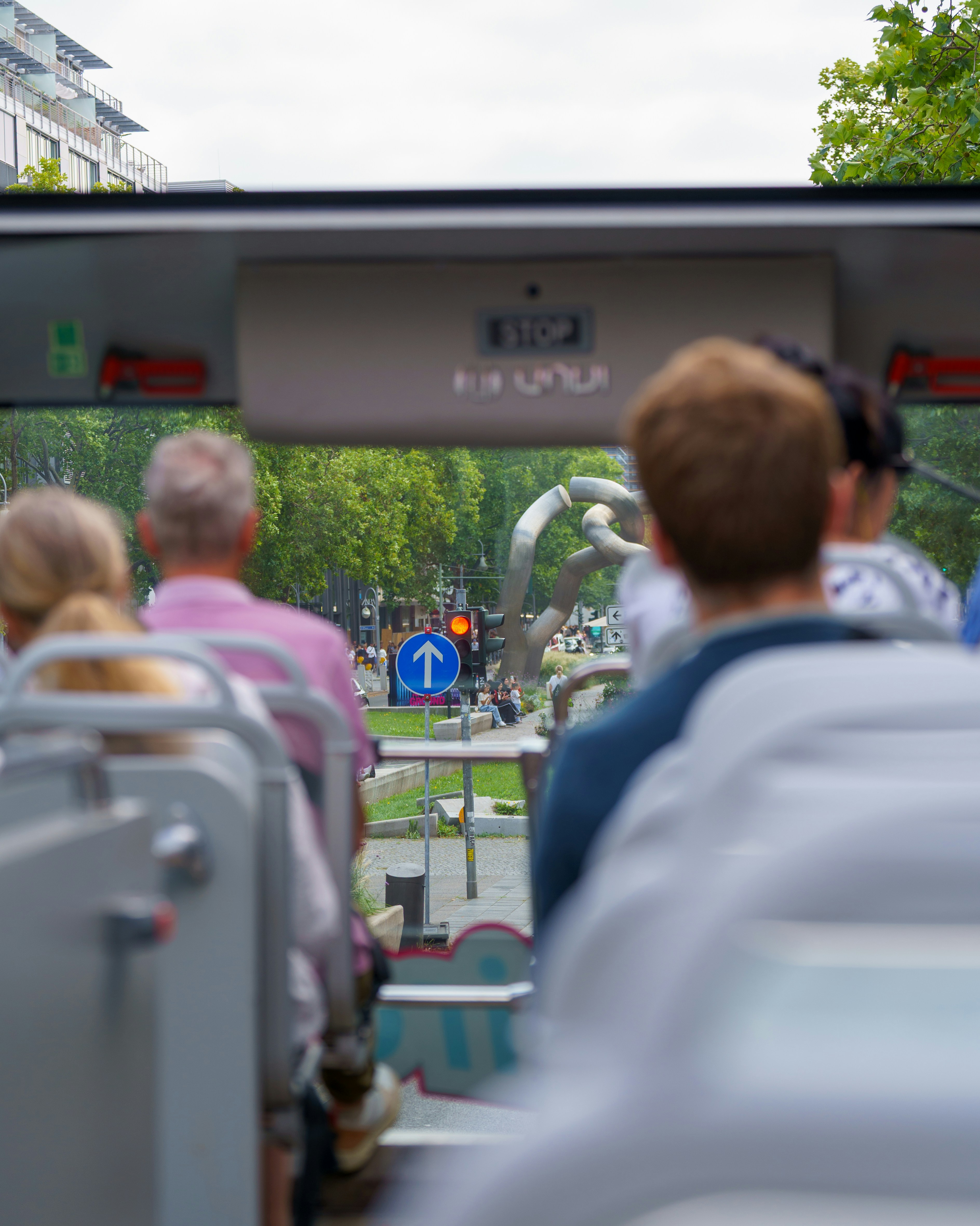 Urban Carousel: Passengers Headed Toward A Blue Circular Sign