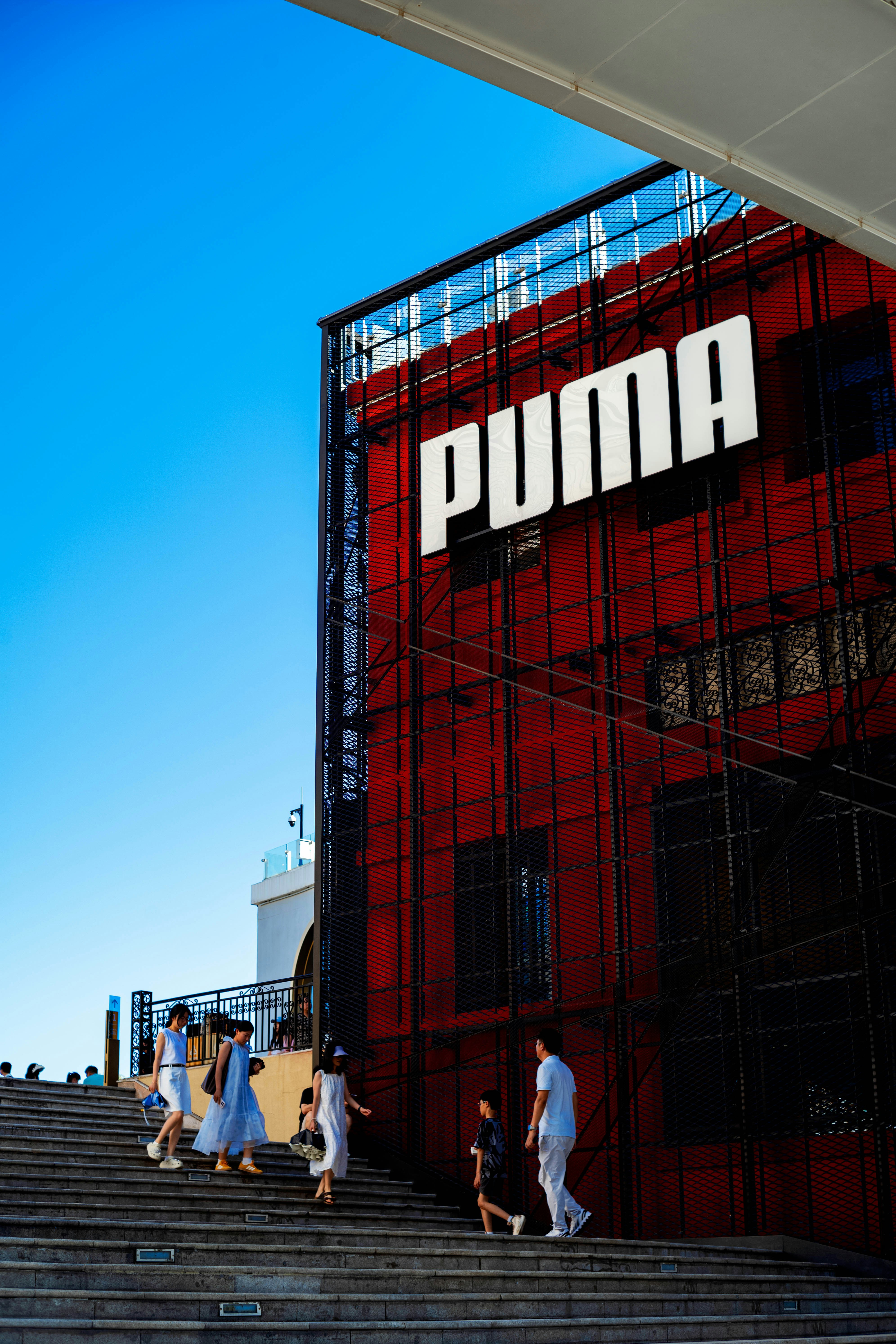 People walk up stairs past a puma store. photo – Free Building Image on ...