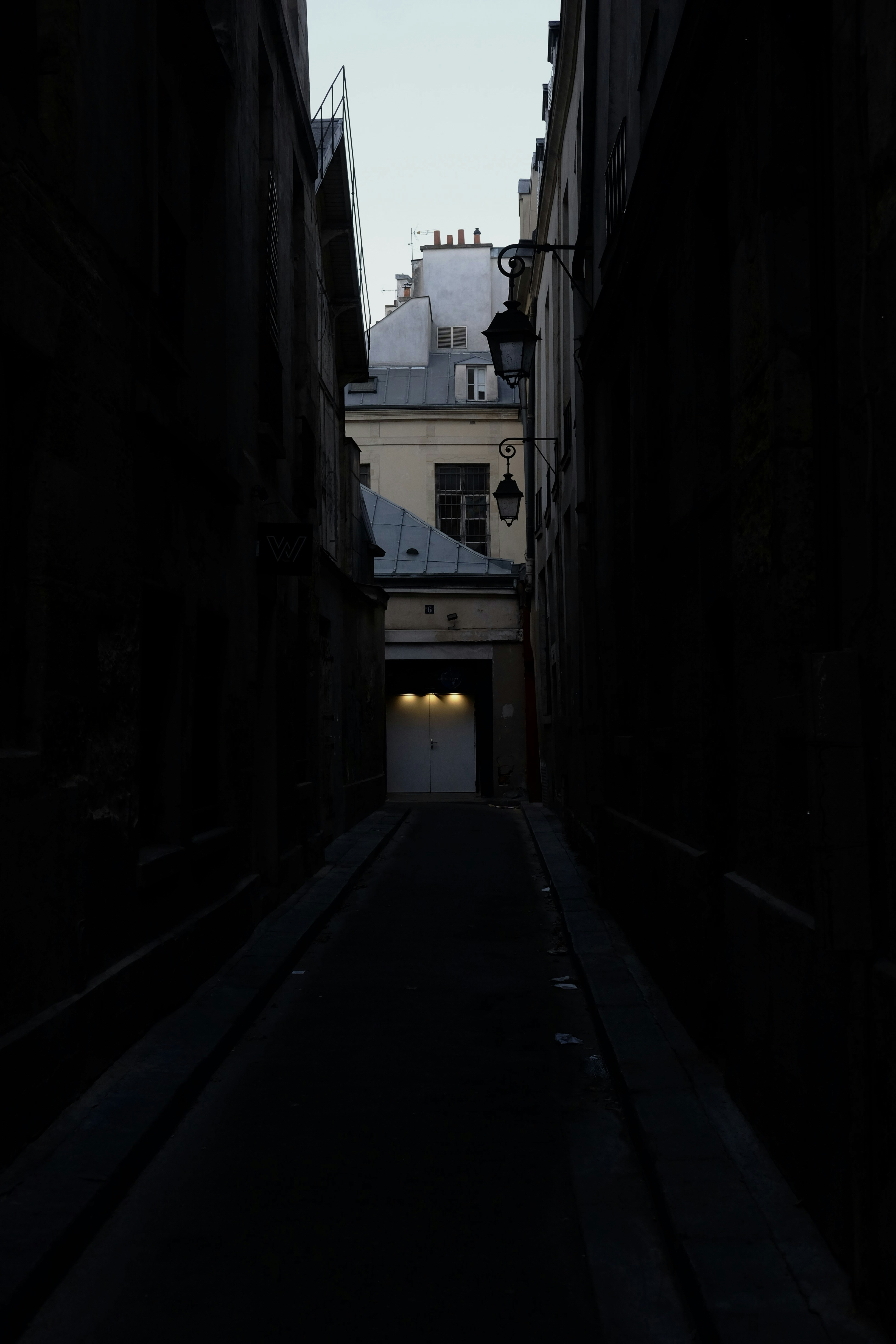 Paris, Fujifilm X-T1 35mm | Narrow dark alleyway leading to illuminated archway.