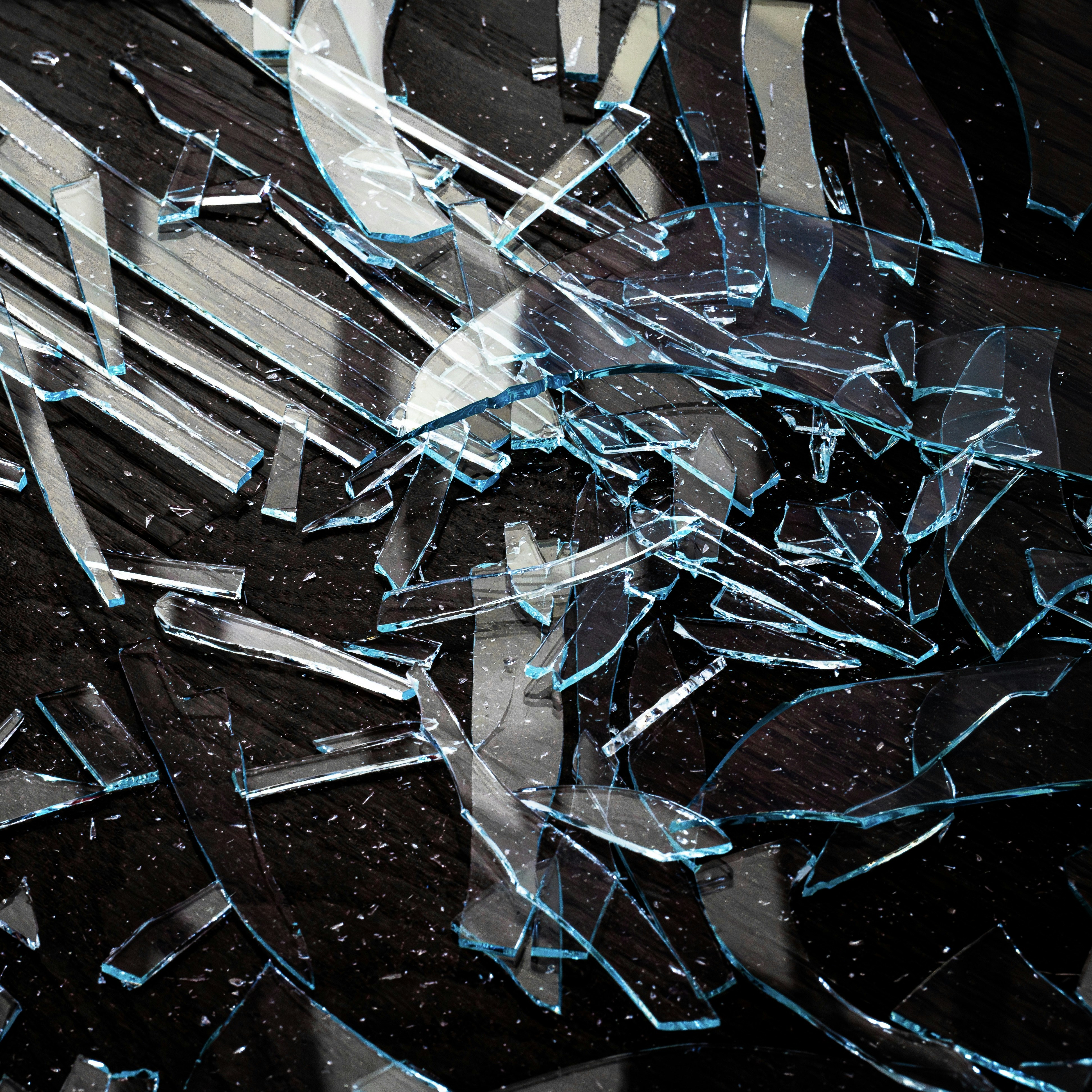 Sharp shards of broken glass scattered on dark surface. photo – Free ...