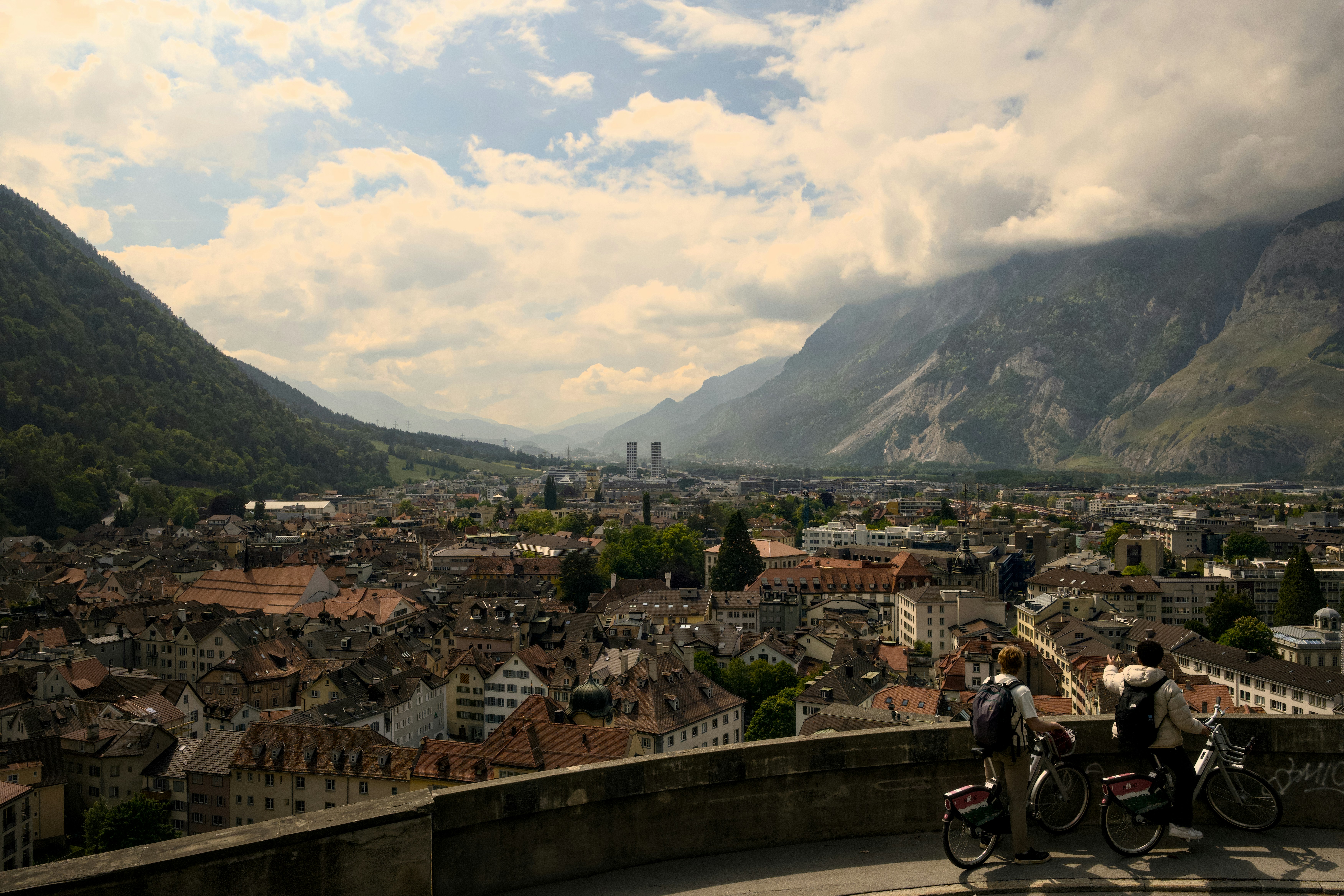 City nestled in a valley with mountains and clouds