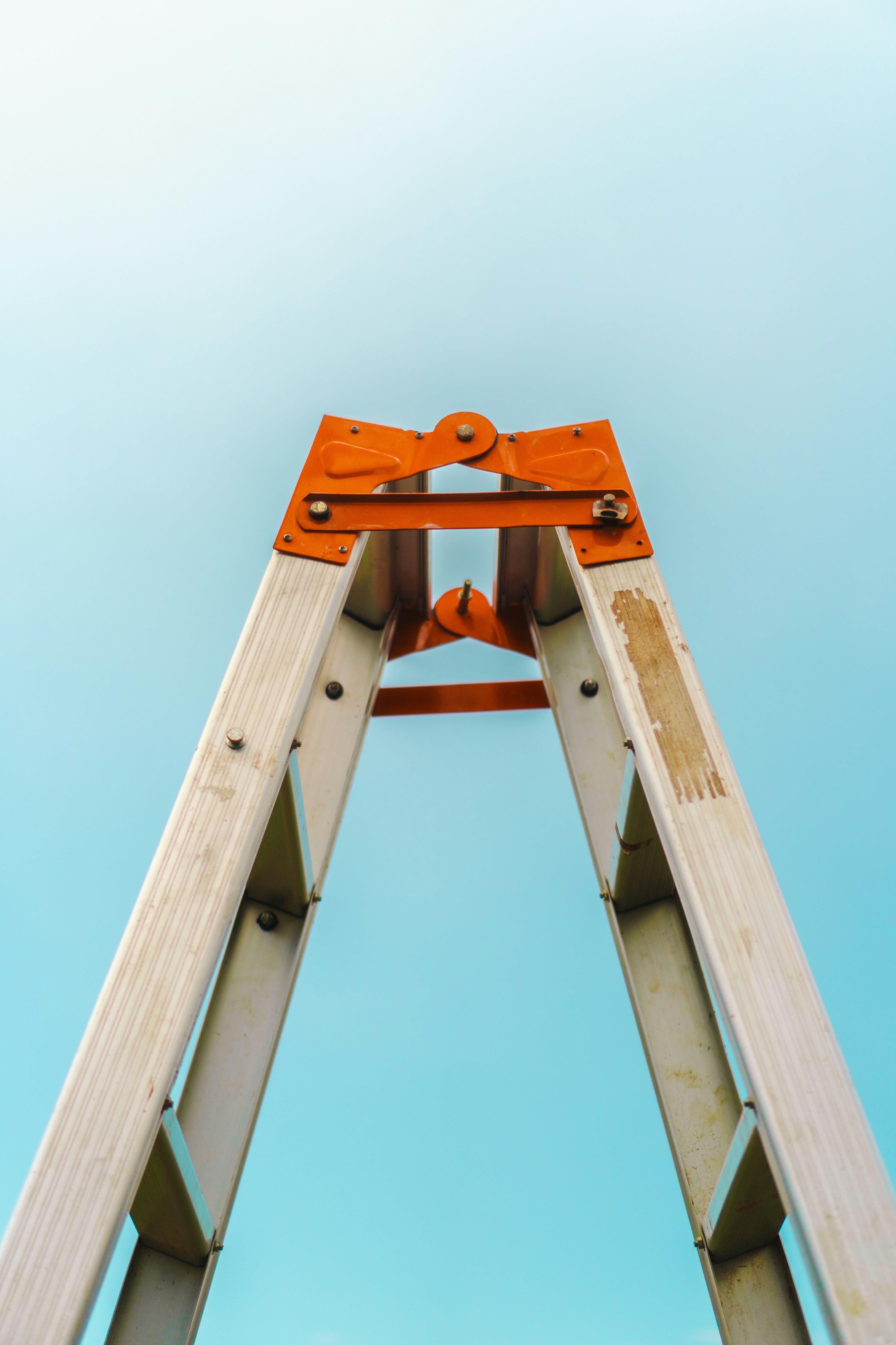 An aluminum ladder against a clear blue sky
