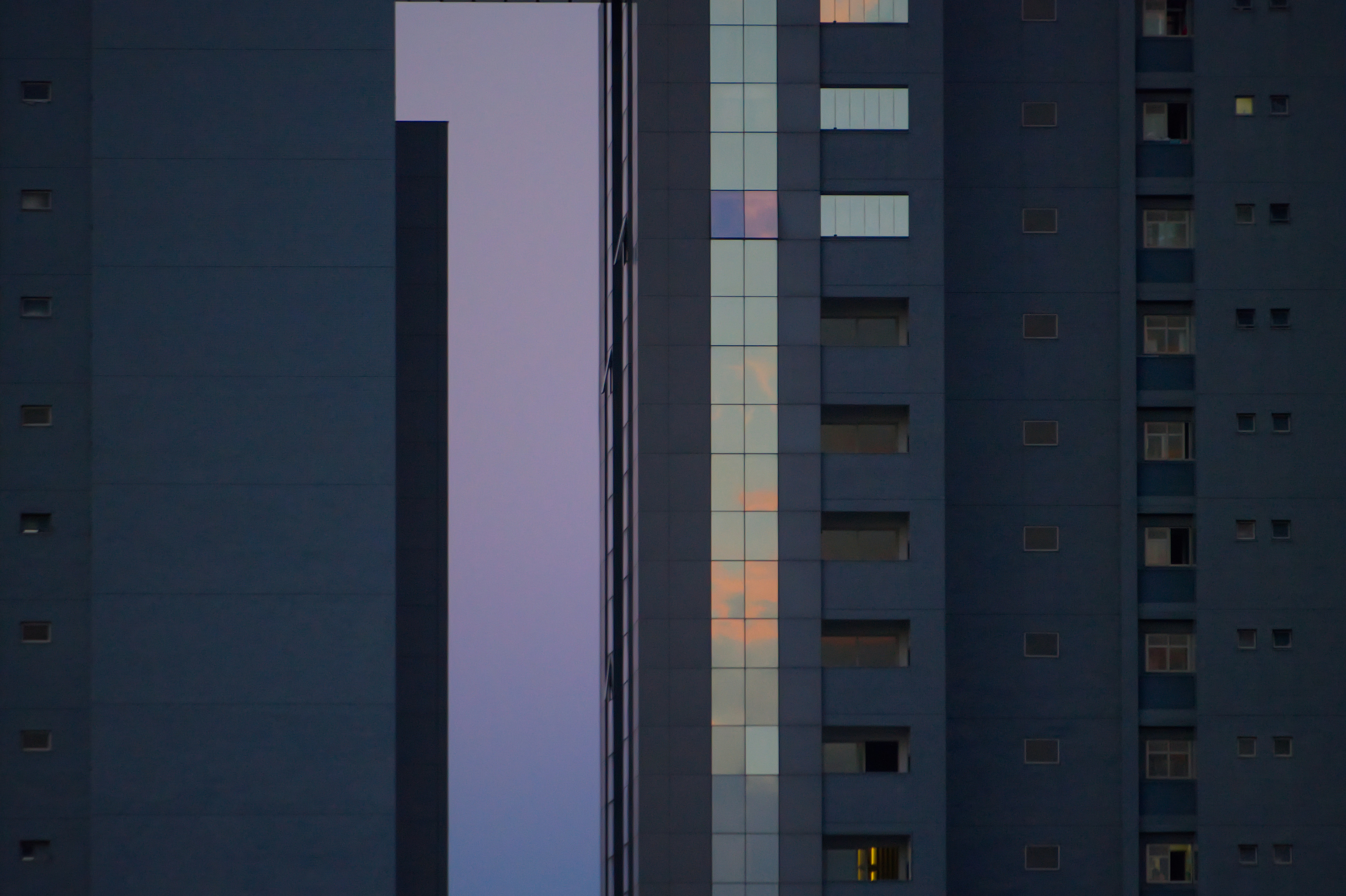 Part of facade of the Infinity building Araranguá, Santa Catarina, Brazil. Architect Osmar Batista do Canto. | Modern skyscraper facade reflects sunset colors at dusk.
