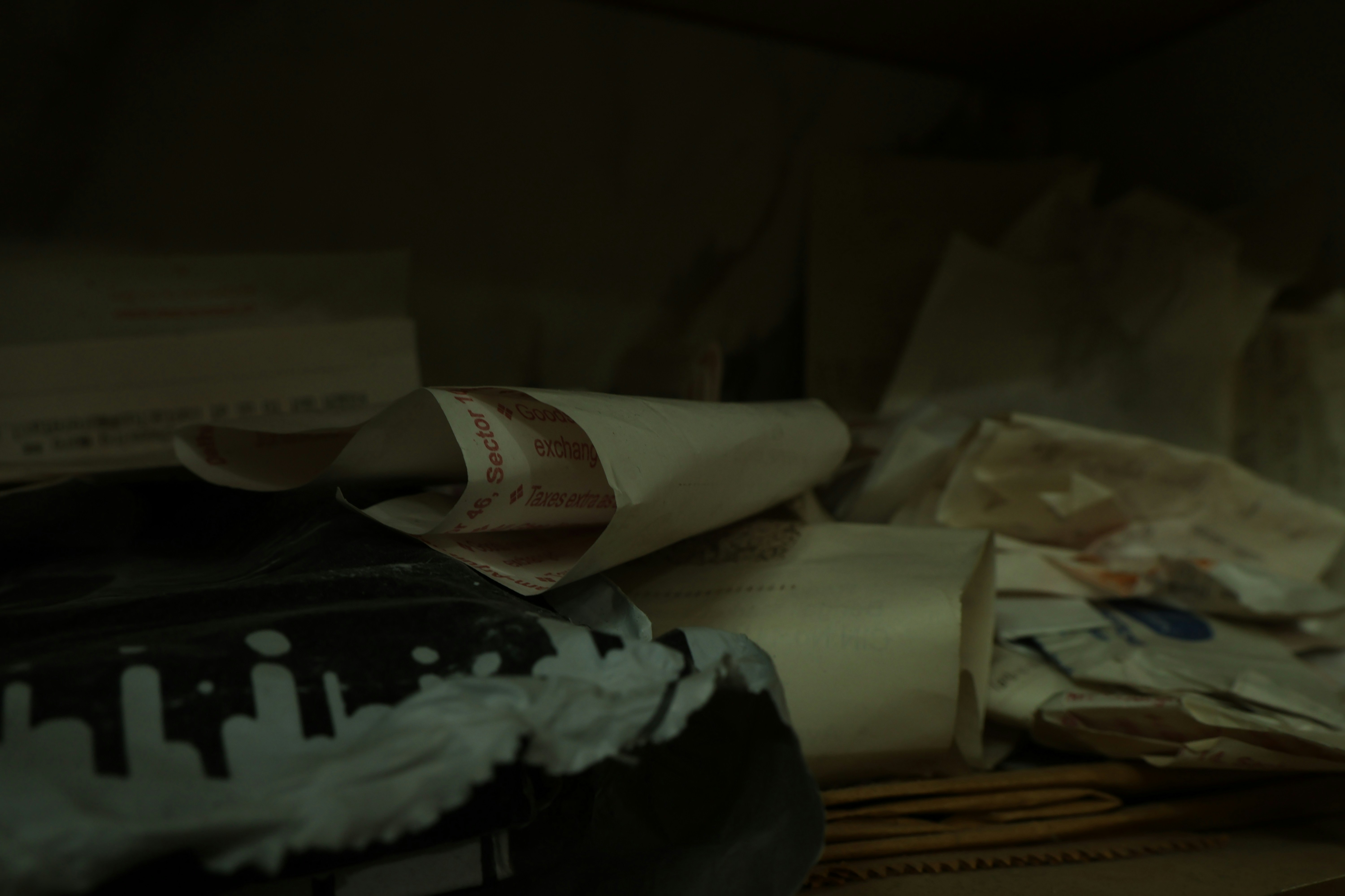 a close up shot of an almirah piled with old bills and wrapper. old vintage look, yellow tones, still calm slice of life image | Pile of old papers and documents on a shelf.