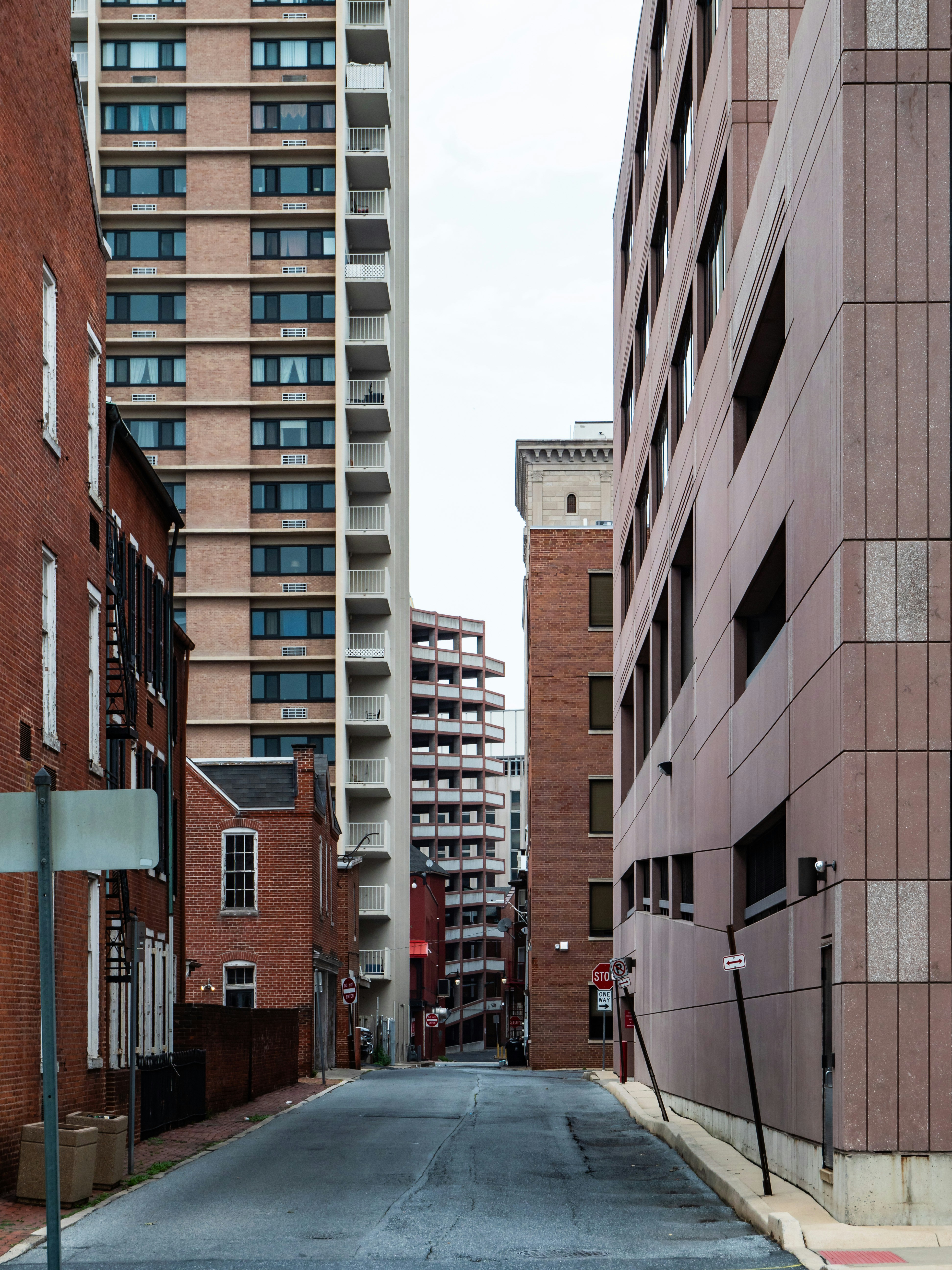 An eerie empty desolated street in a town | Narrow city street between brick and modern buildings