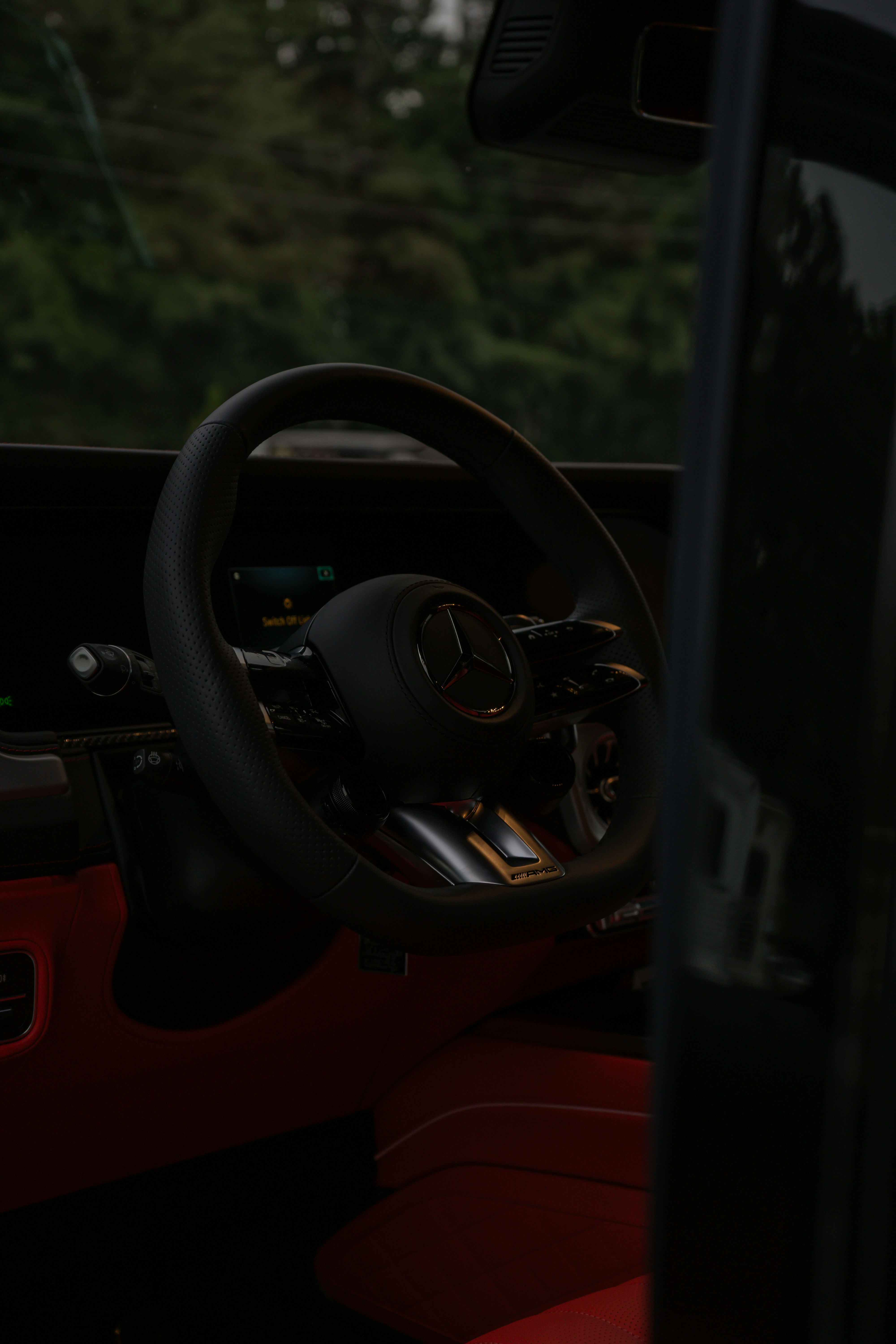 Luxury car interior with red seats and steering wheel.