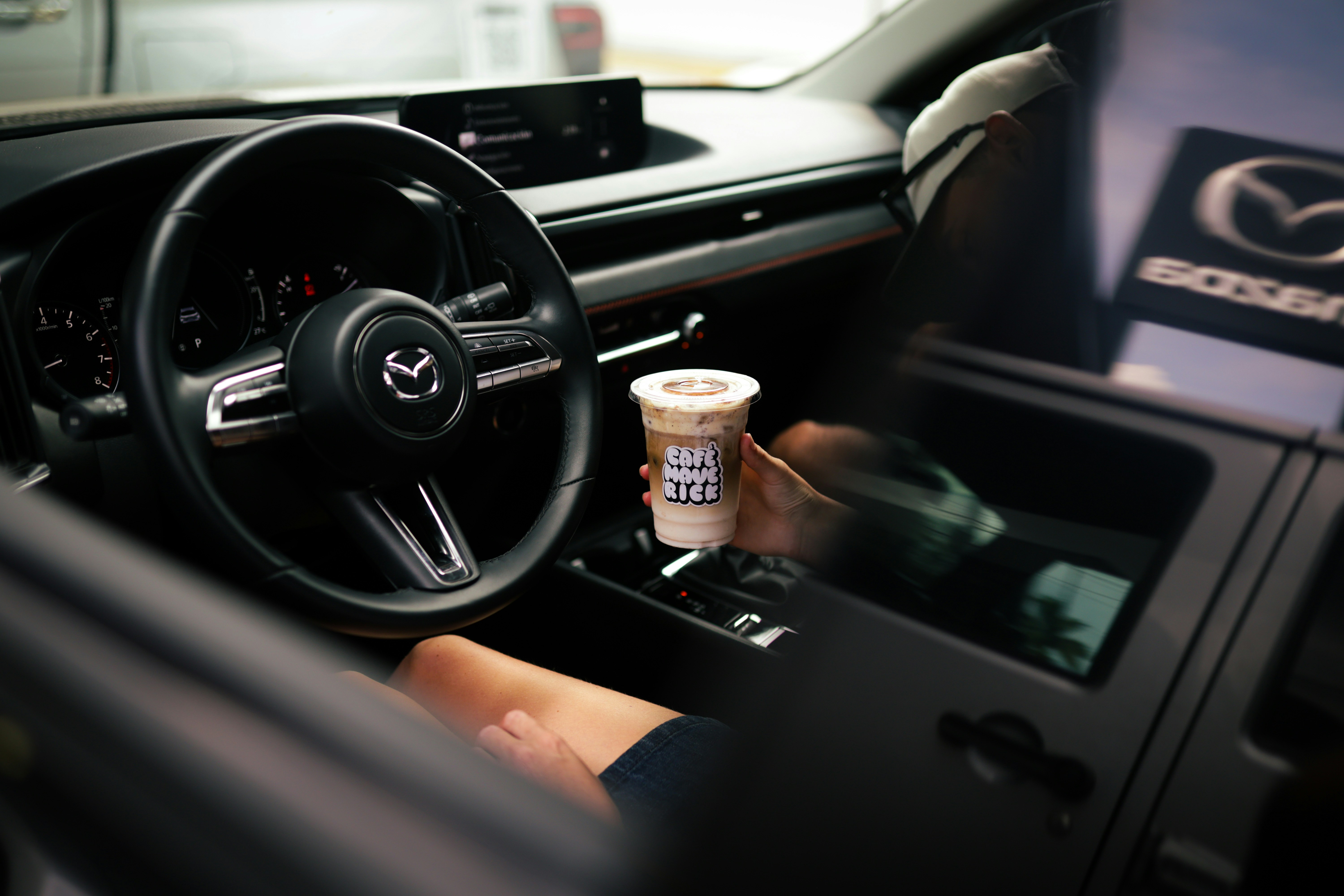 Un café para manejar despierto | Person holding iced coffee in a car