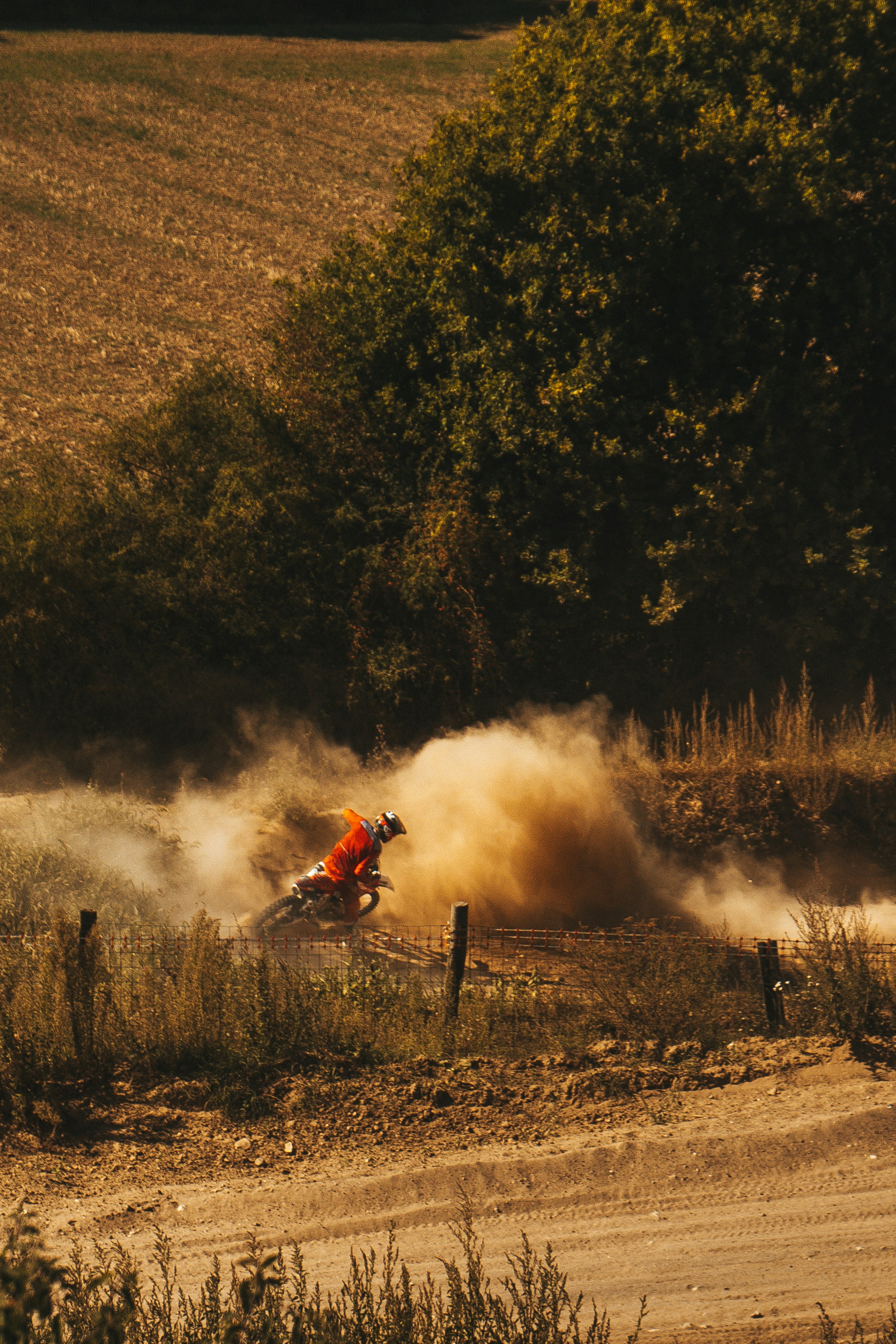 Motorcyclist kicking up dust on a dirt track