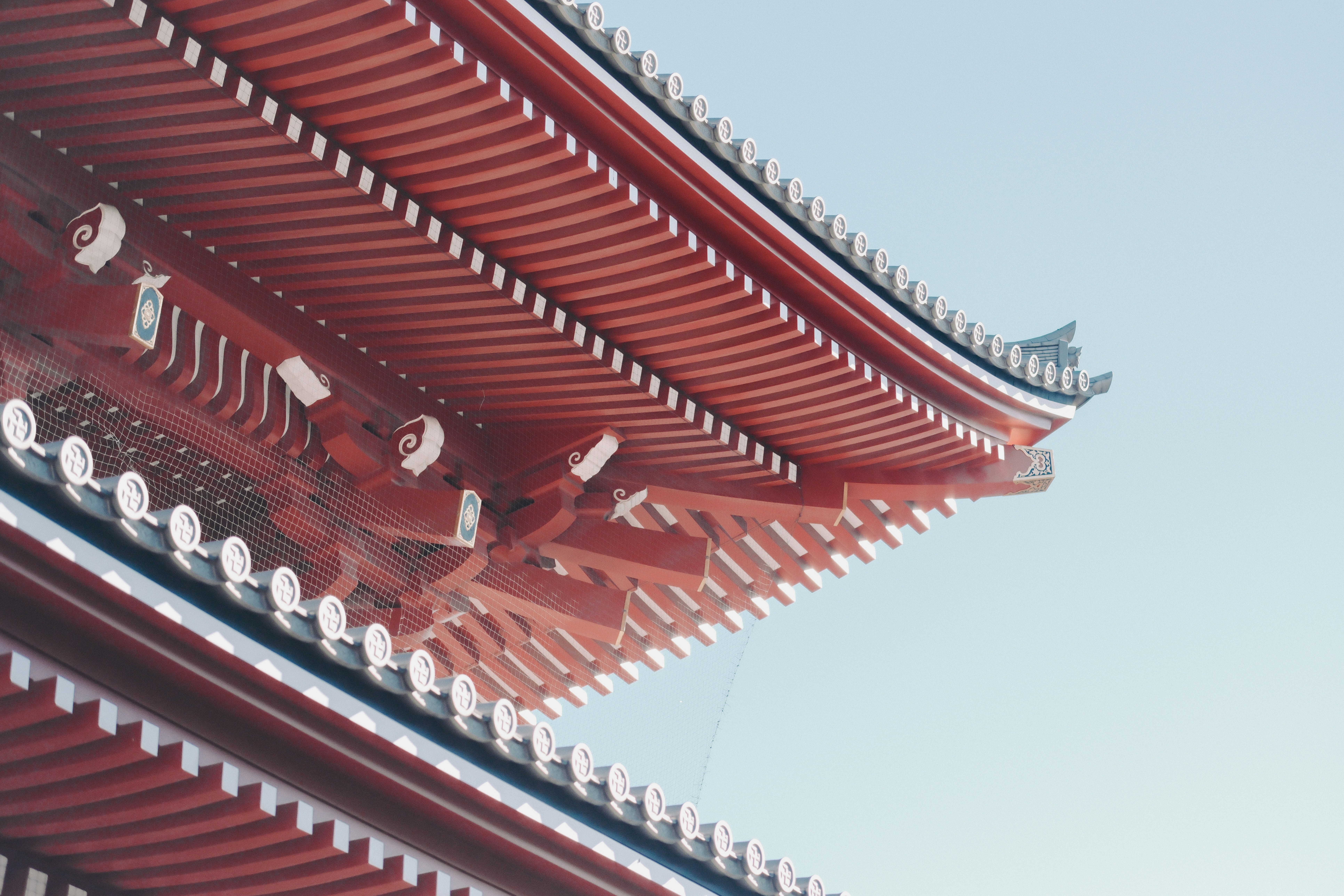 Red tiered roof of a japanese temple against sky