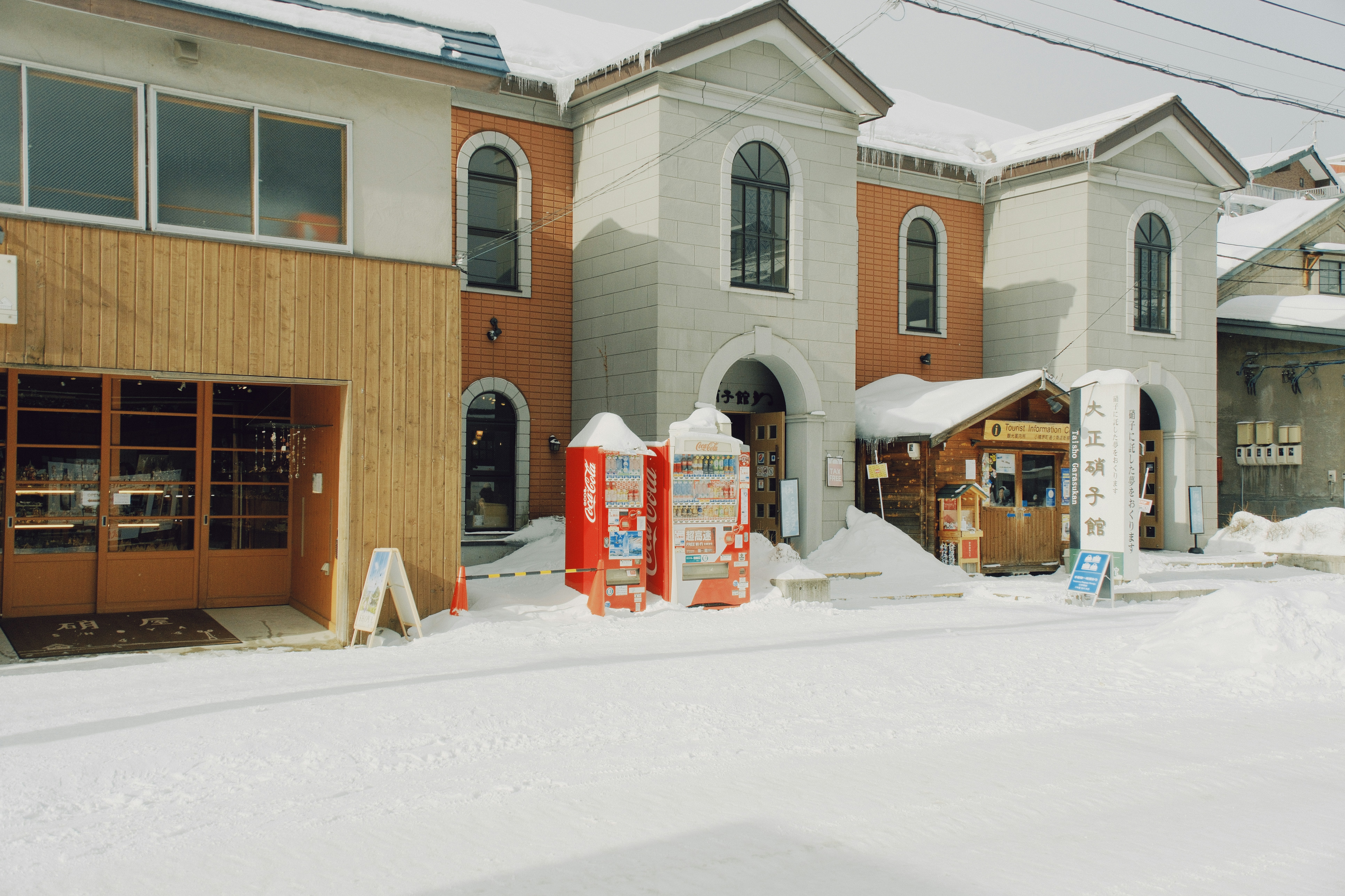 Snowy street with buildings and shops in winter.