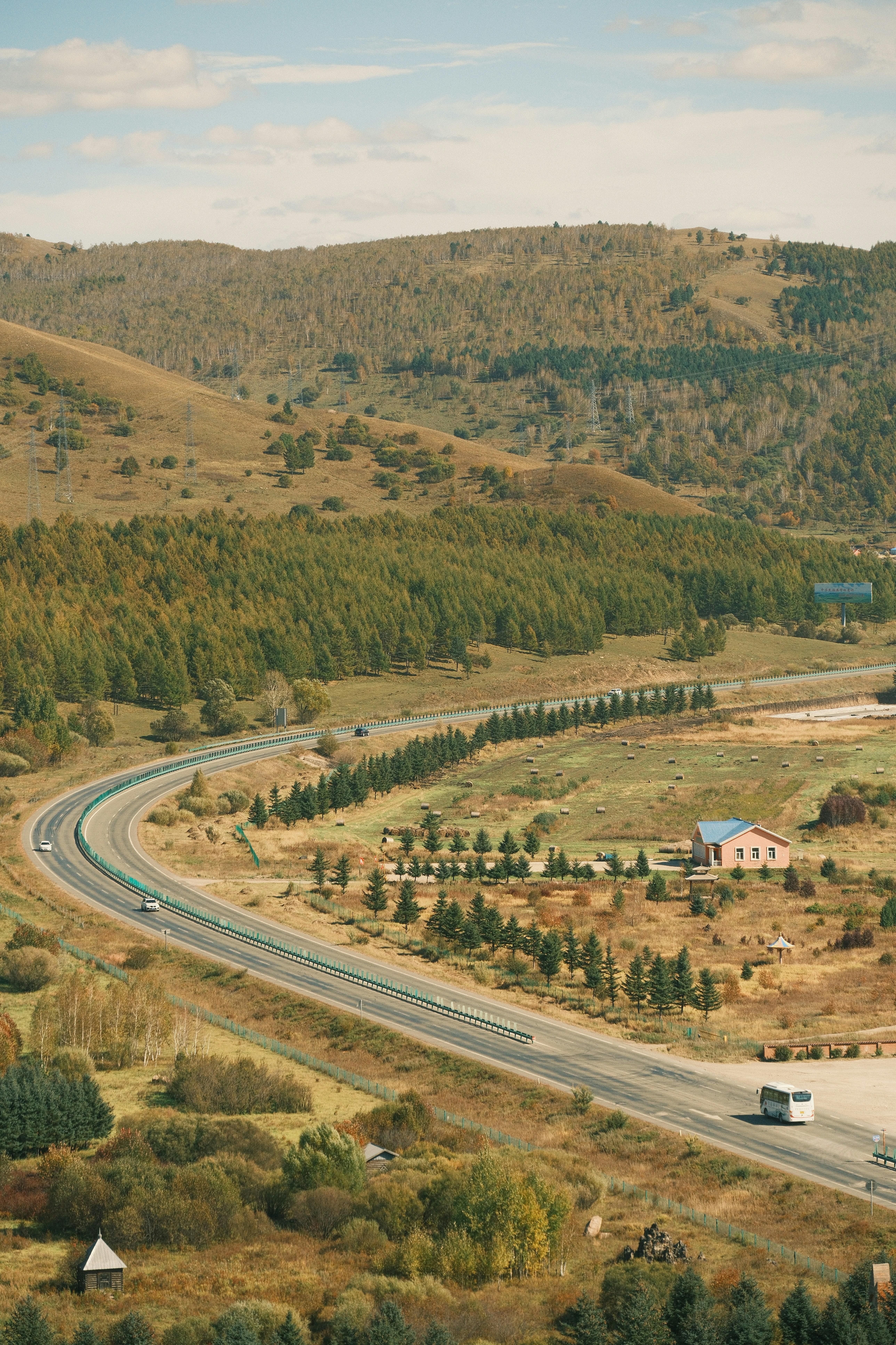Curving highway through rolling hills and autumn trees