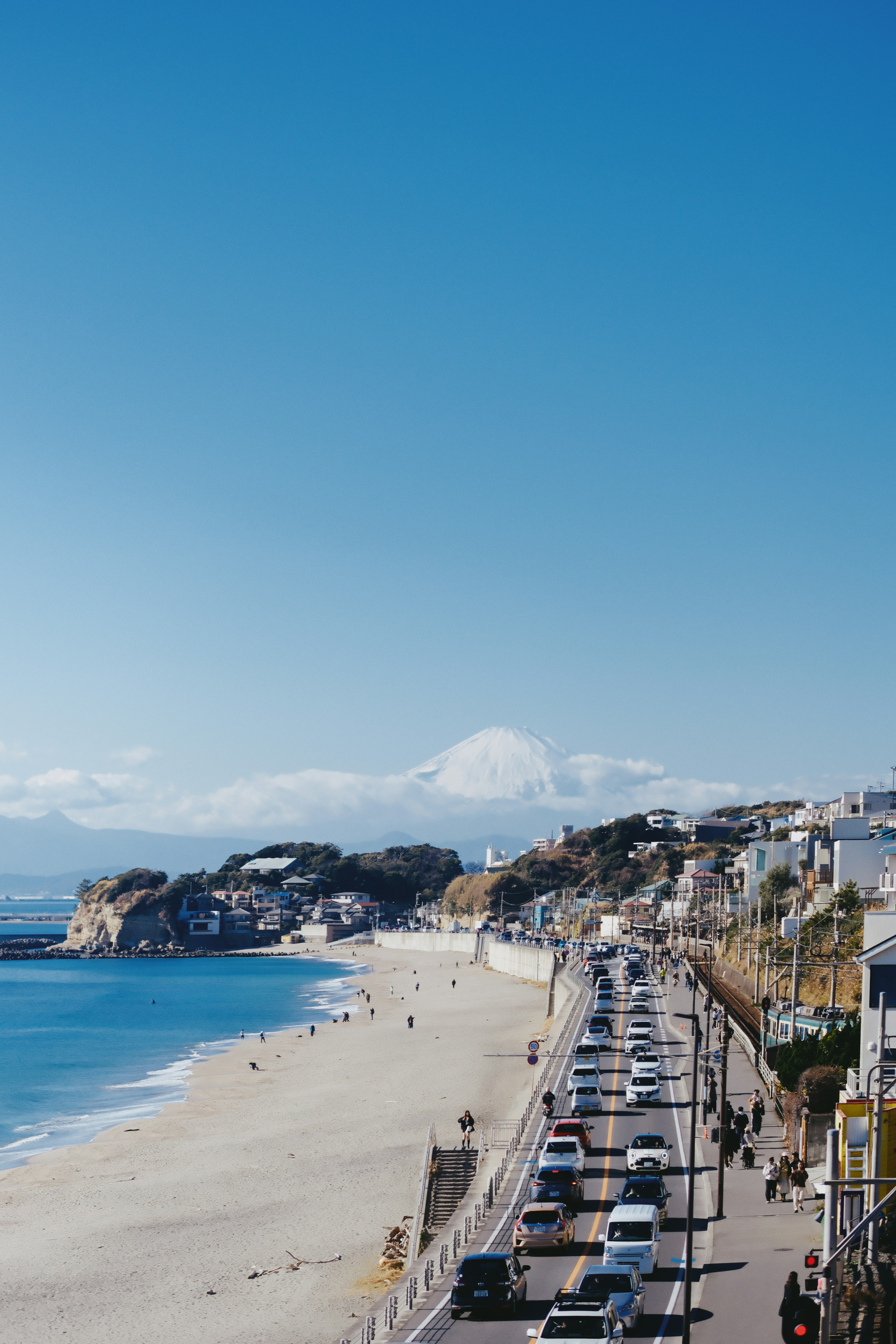 Coastal Boulevard Beneath a Snow-Capped Peak