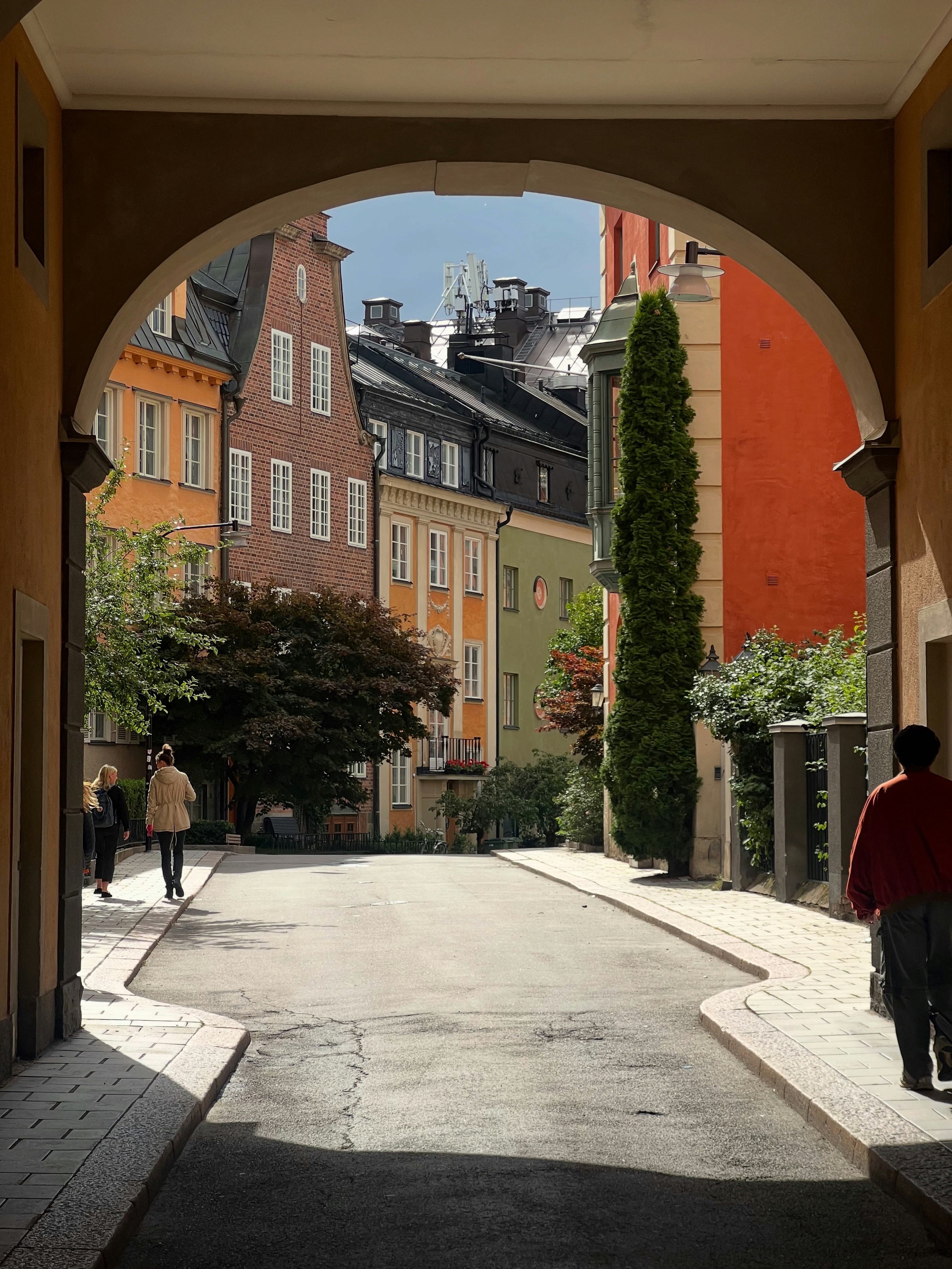 Colorful buildings line a european street viewed through an archway.