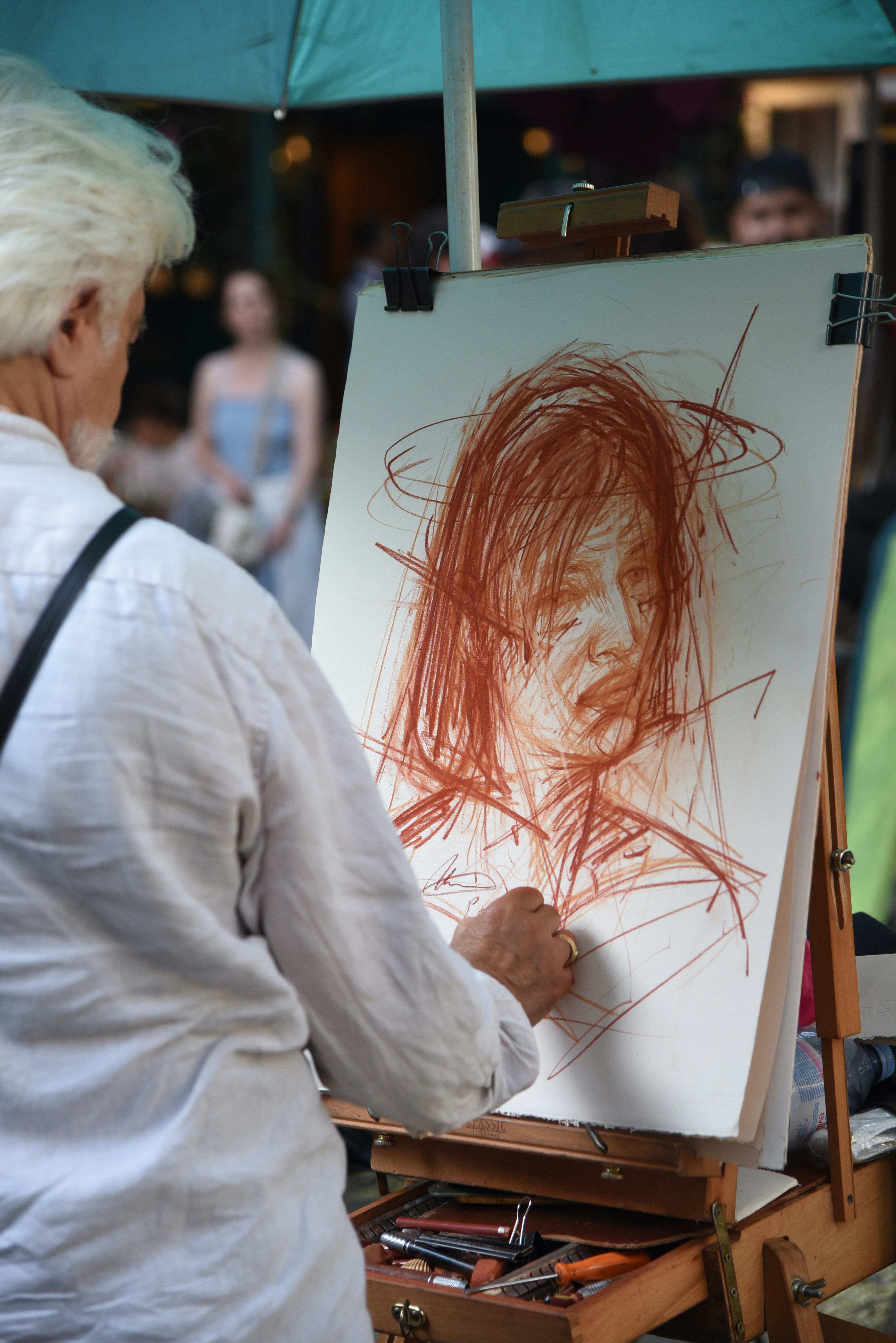 Sketching the Muse: A Street Artist Captures a Portrait at Eye Level