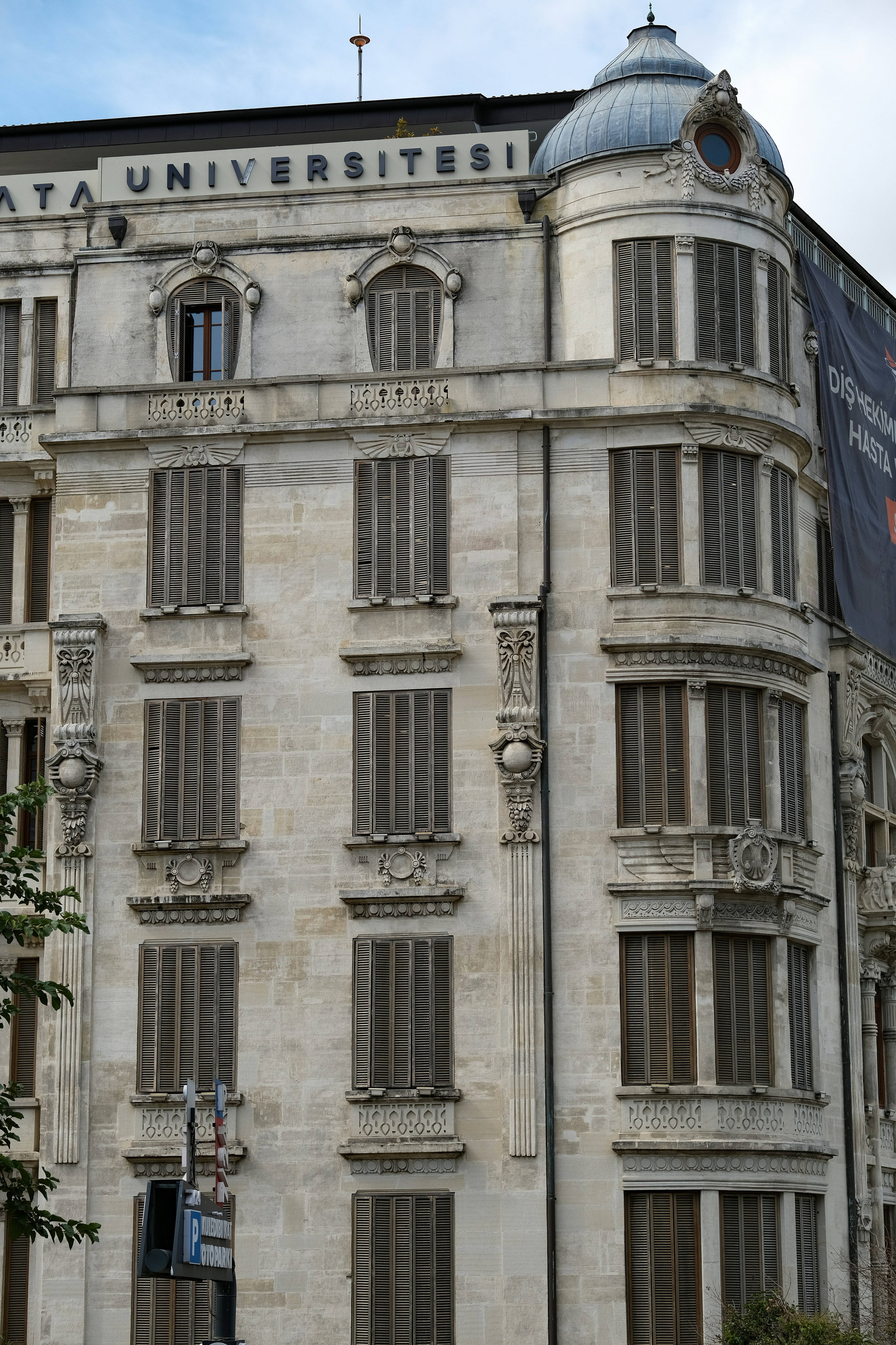 Ornate stone building with closed shutters and dome.