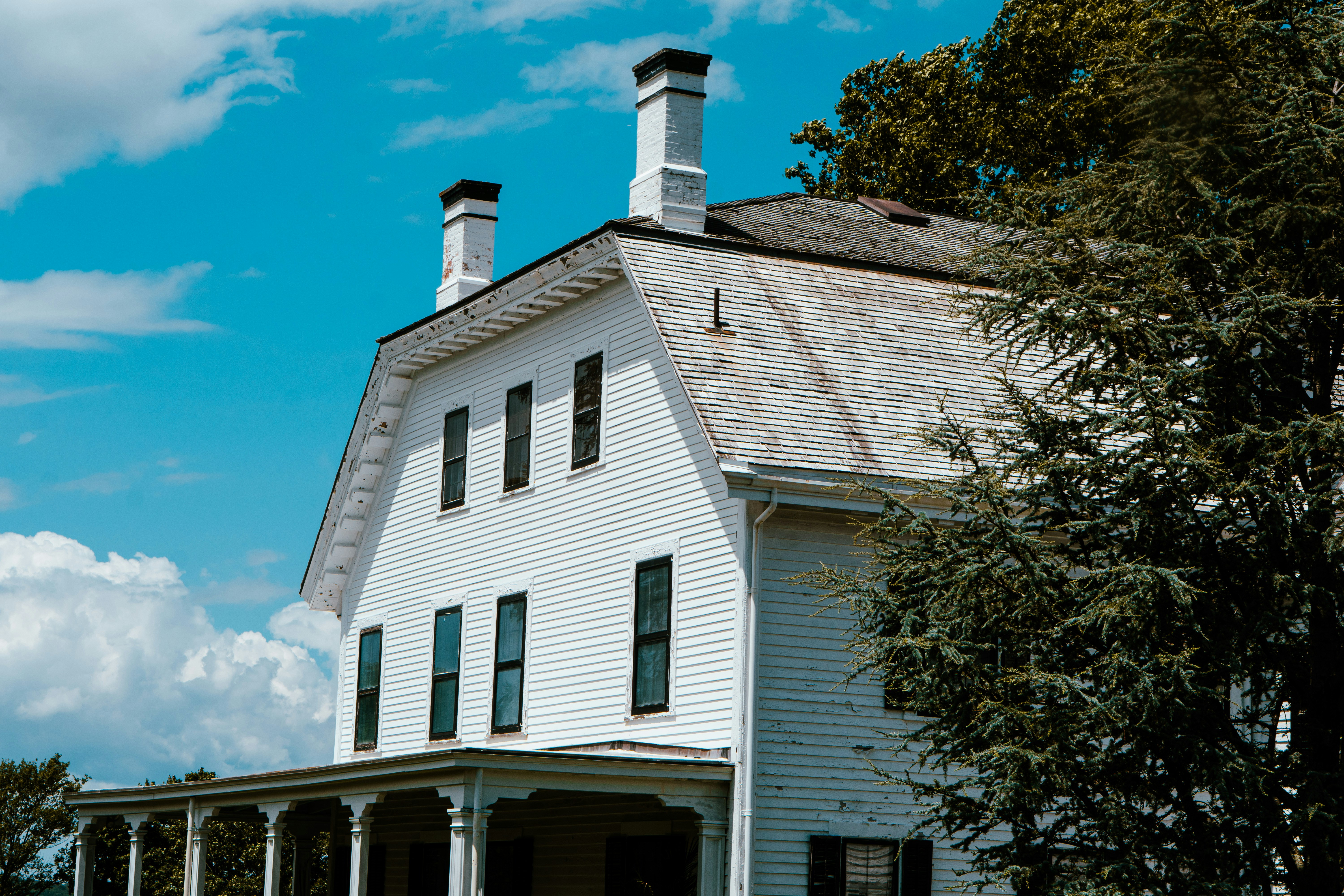Mansion located in Newport, Rhode Island | White house with a porch and two chimneys.