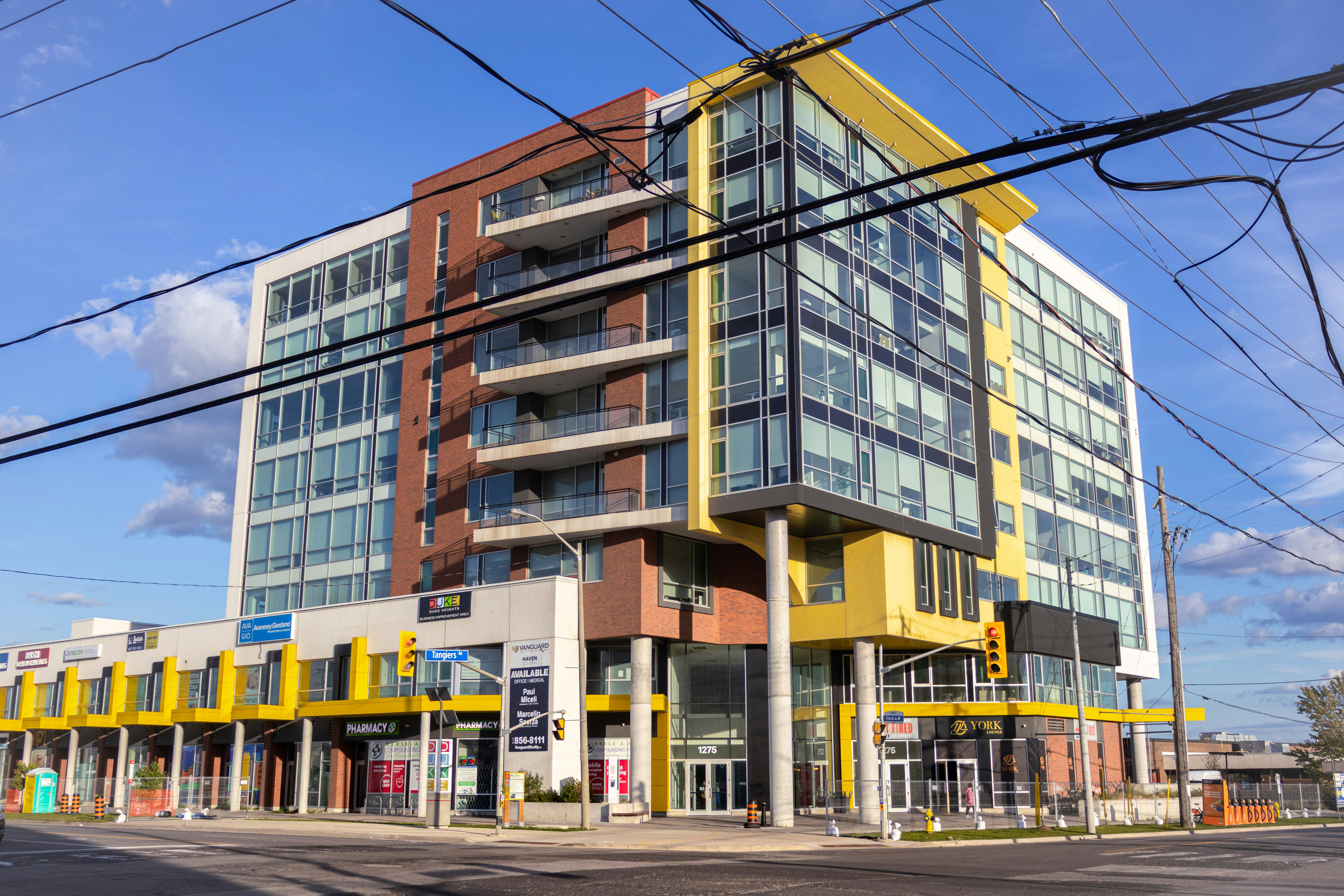 Shot in Duke Heights | Modern building with yellow and brick facade on corner.