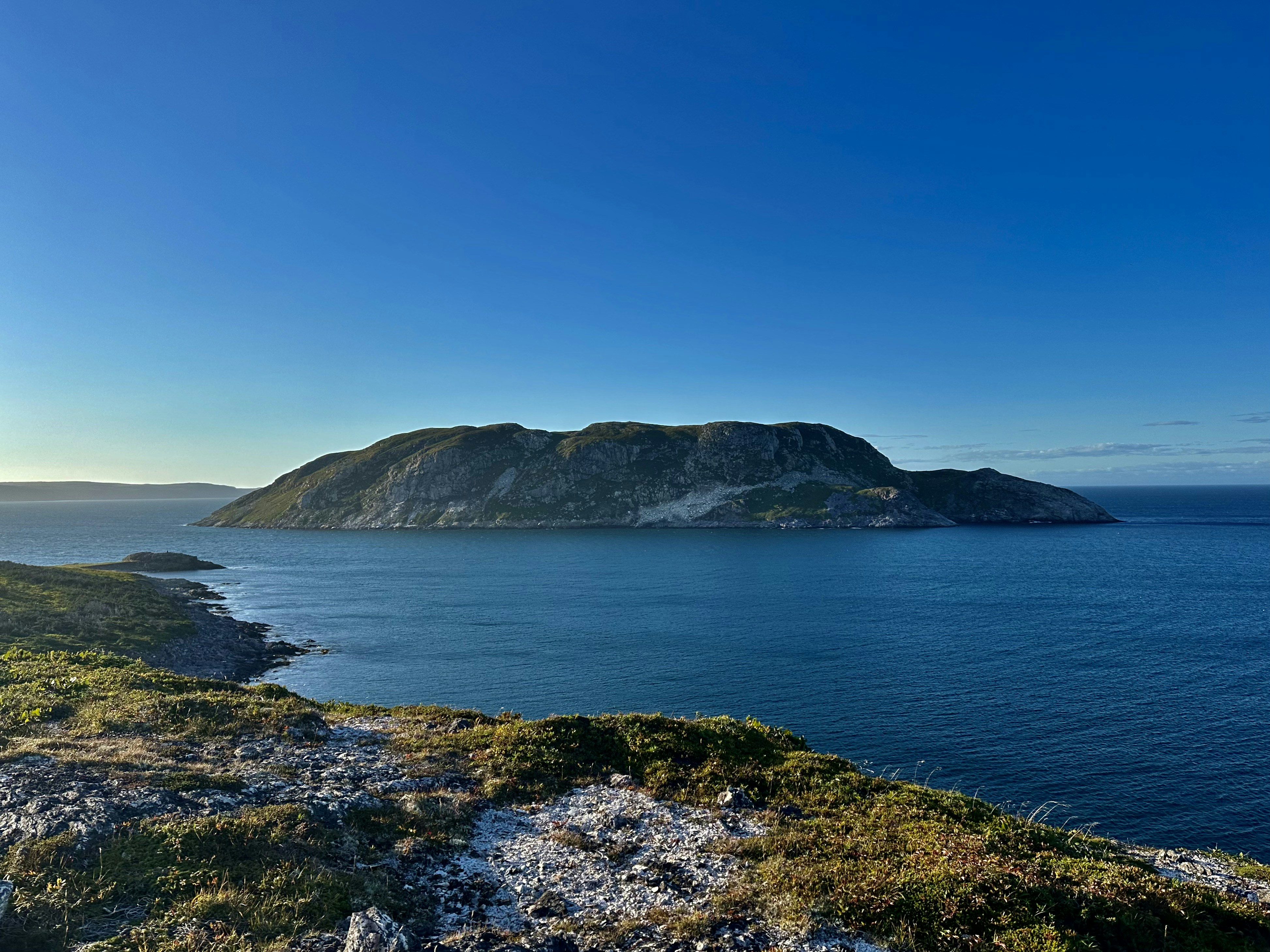 Island in the ocean under a clear blue sky