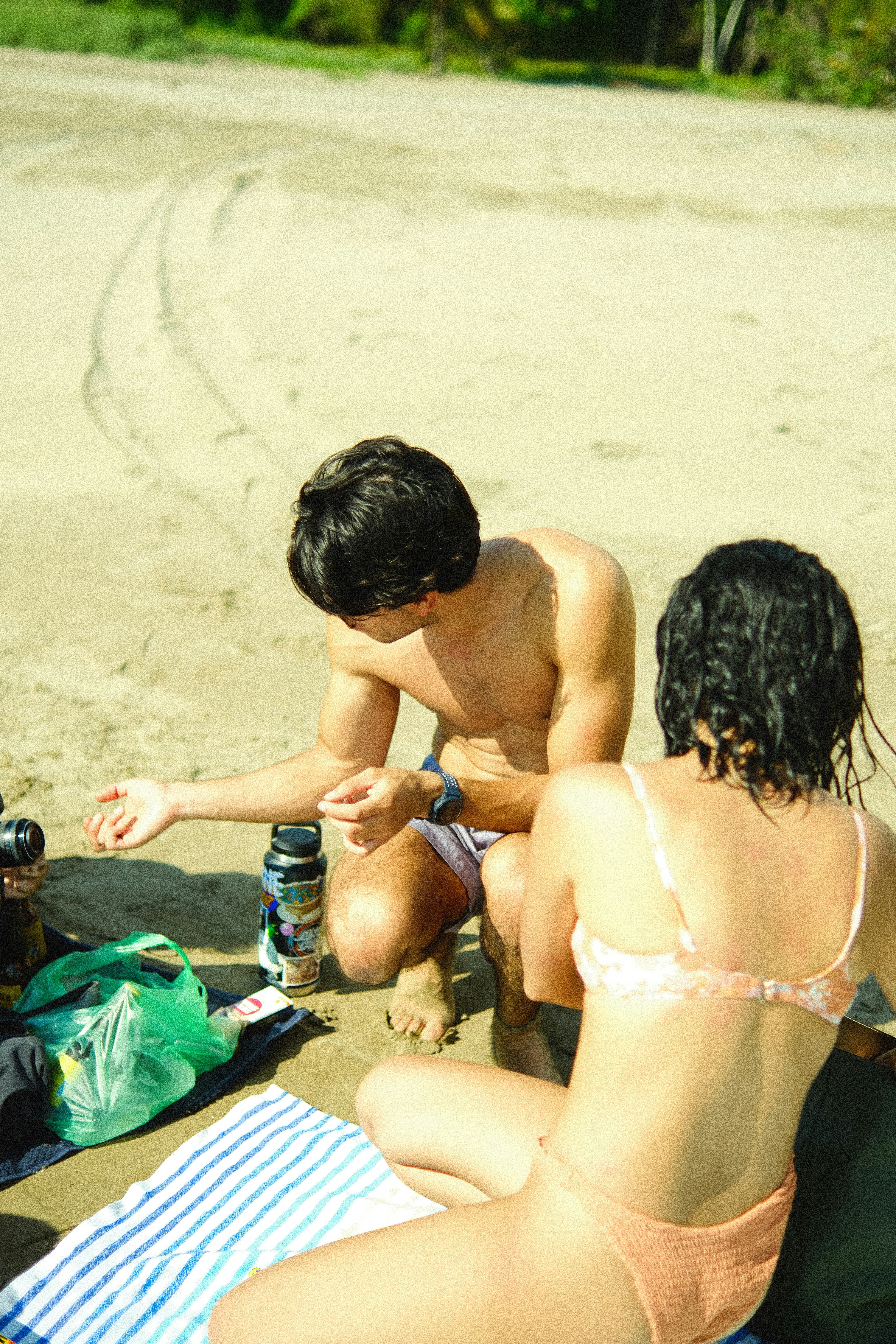 El verano se va, pero los amigos se quedan | Couple relaxing on a sandy beach together.