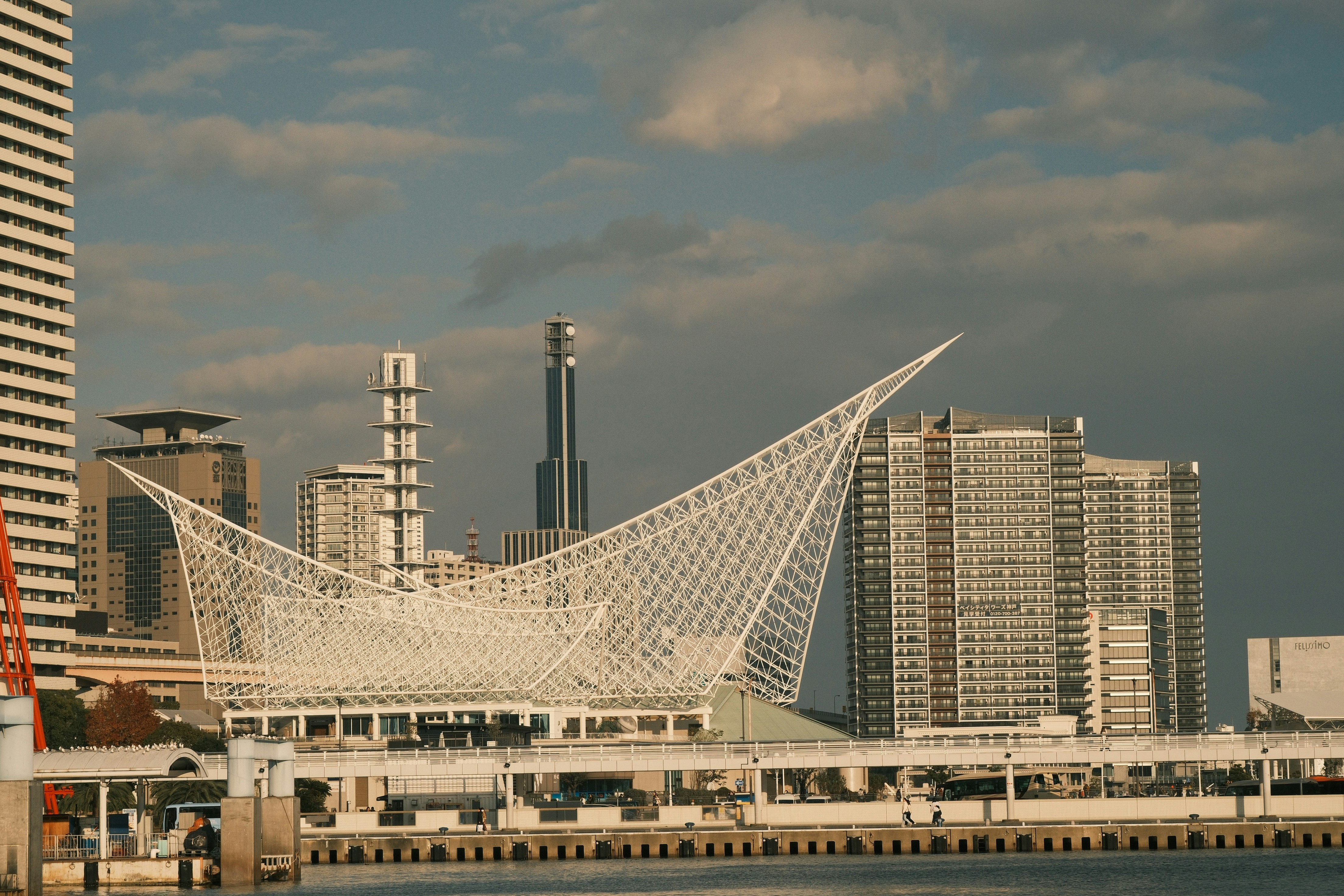 Modern white building with city skyline and water
