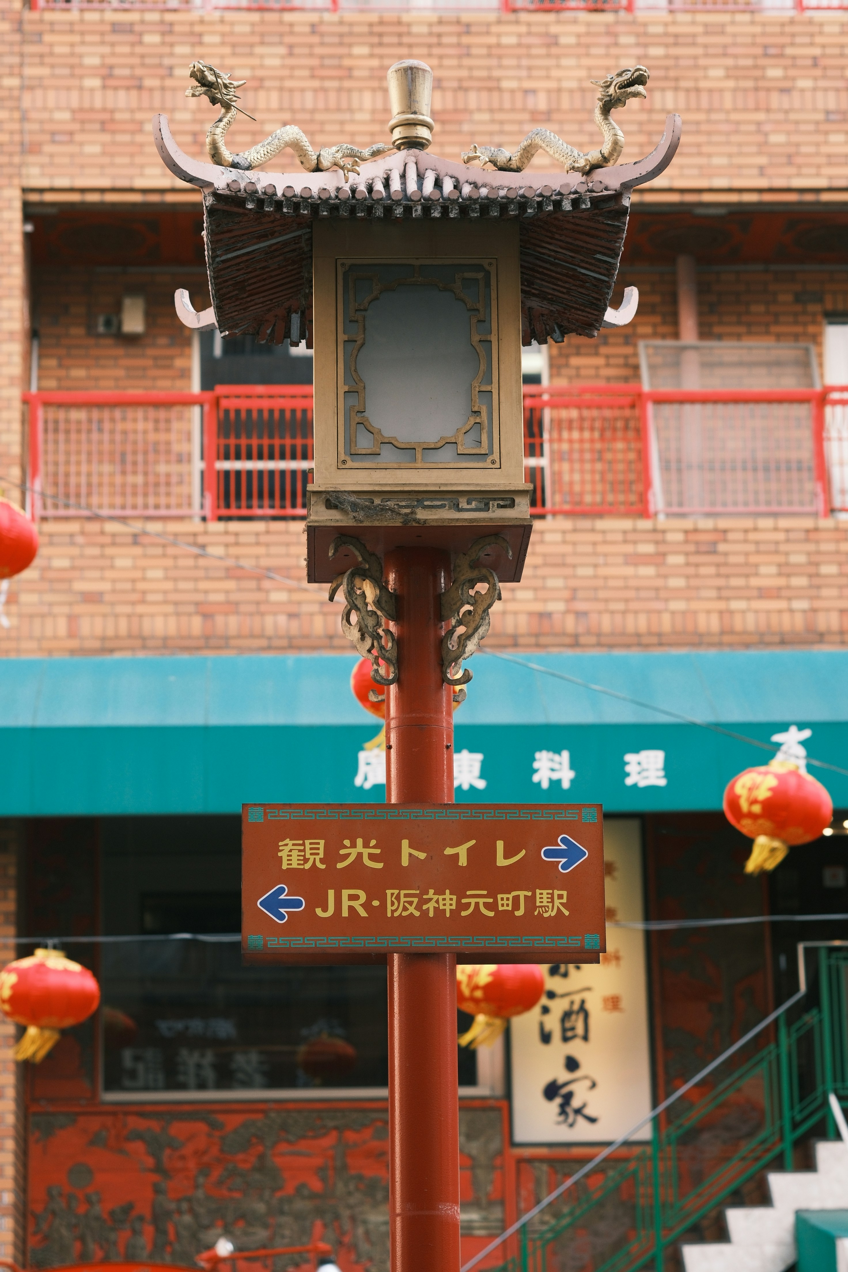 Ornate street lamp with asian architectural elements and signs.
