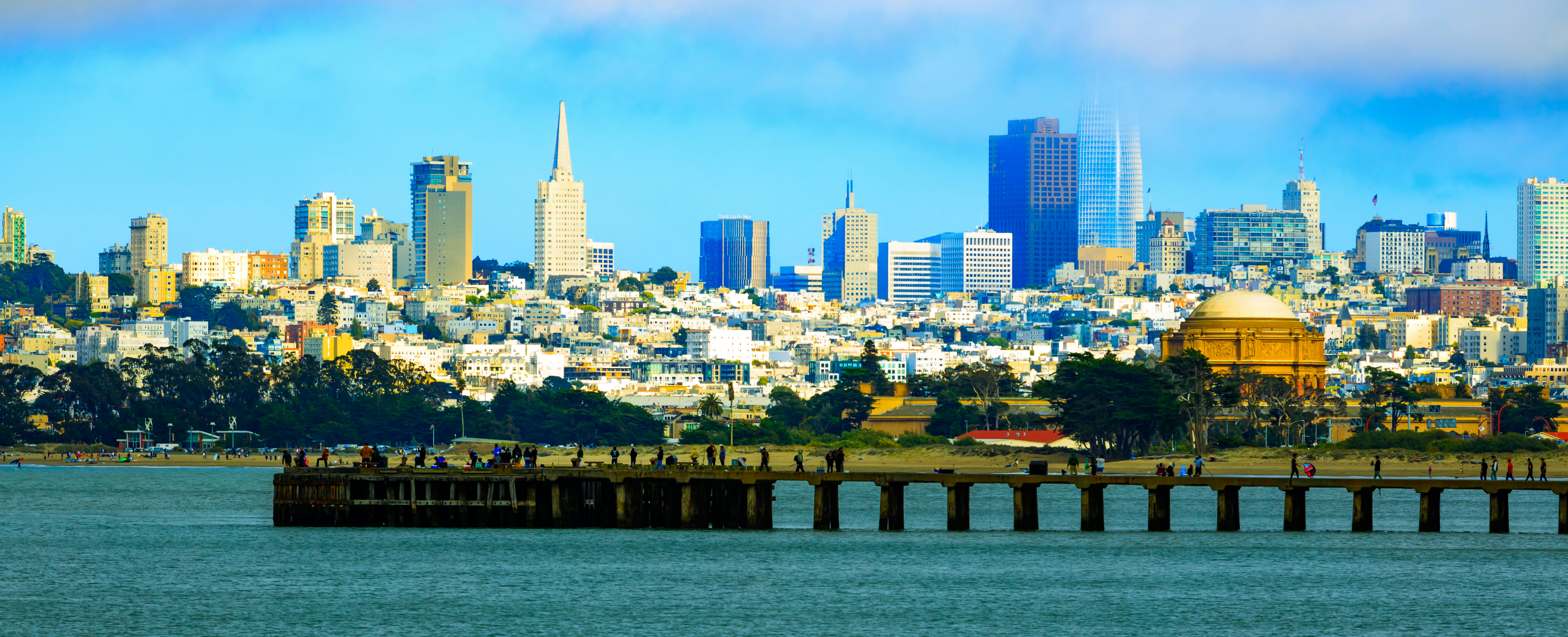 Golden Gate Park and San Francisco skyline viewed from a distance, showcasing iconic architecture against a vibrant sky.