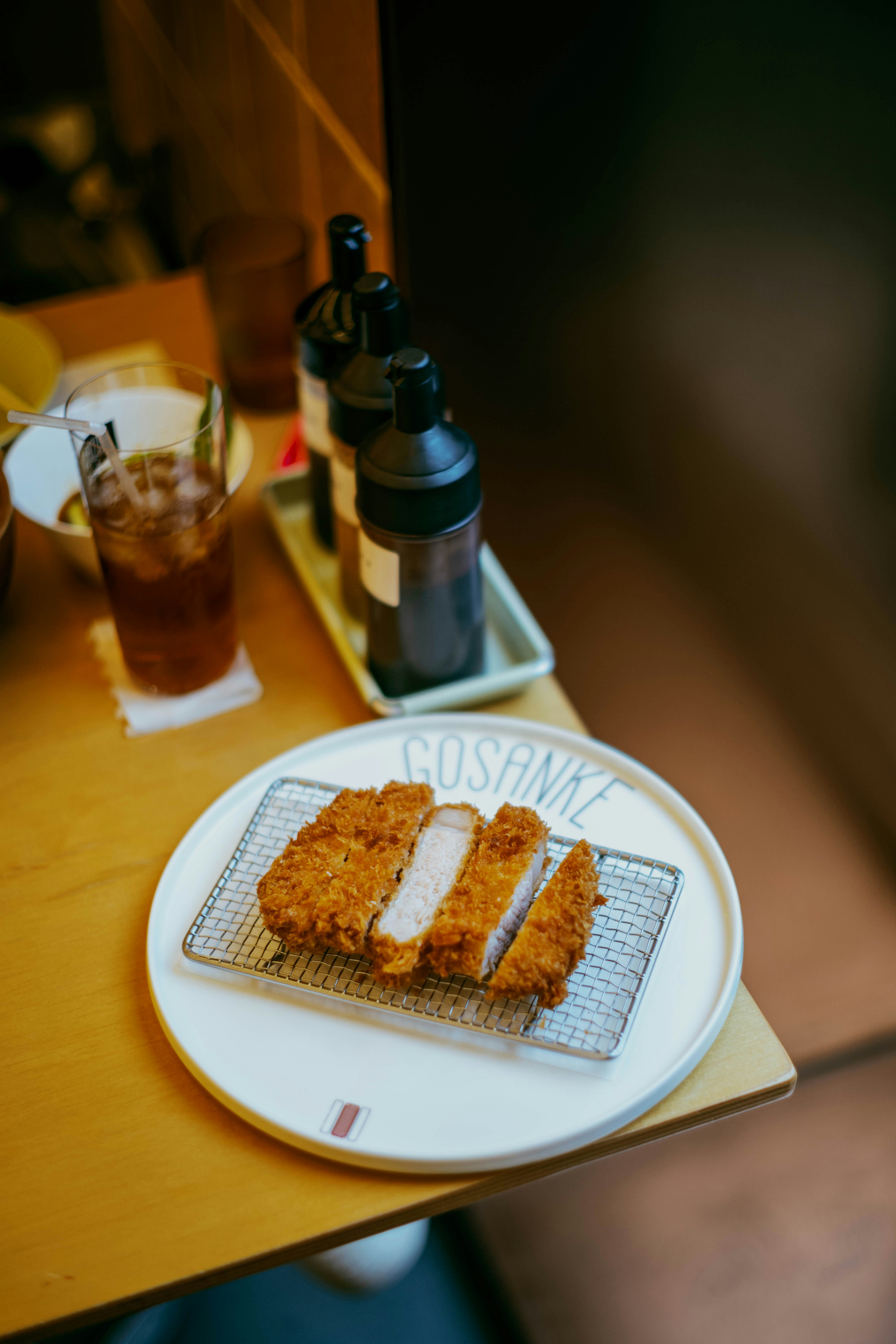 Quiet Crunch: Crispy Katsu Resting on a Wire Rack at a Casual Eatery