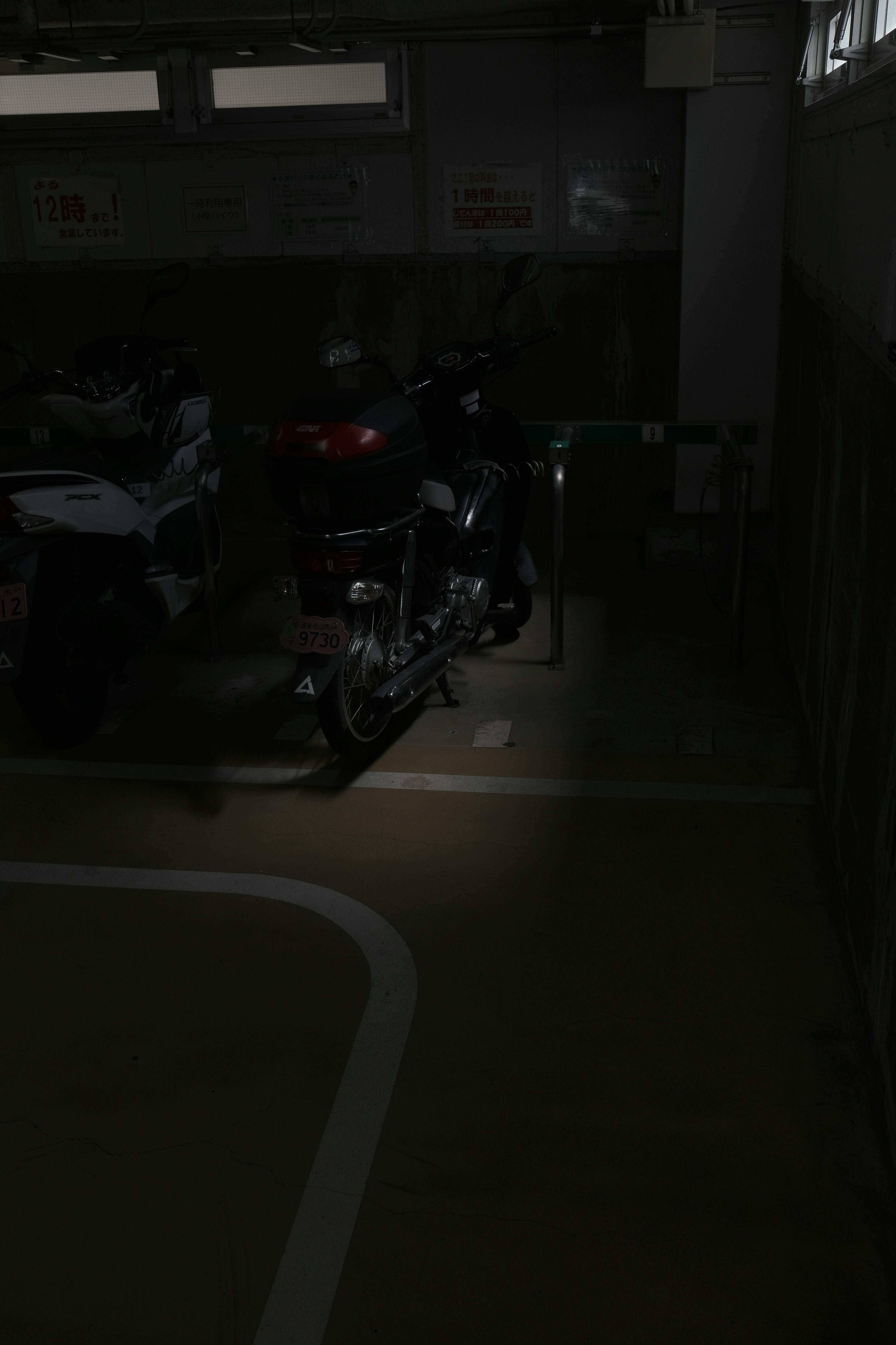 Motorcycles parked in a dimly lit garage.