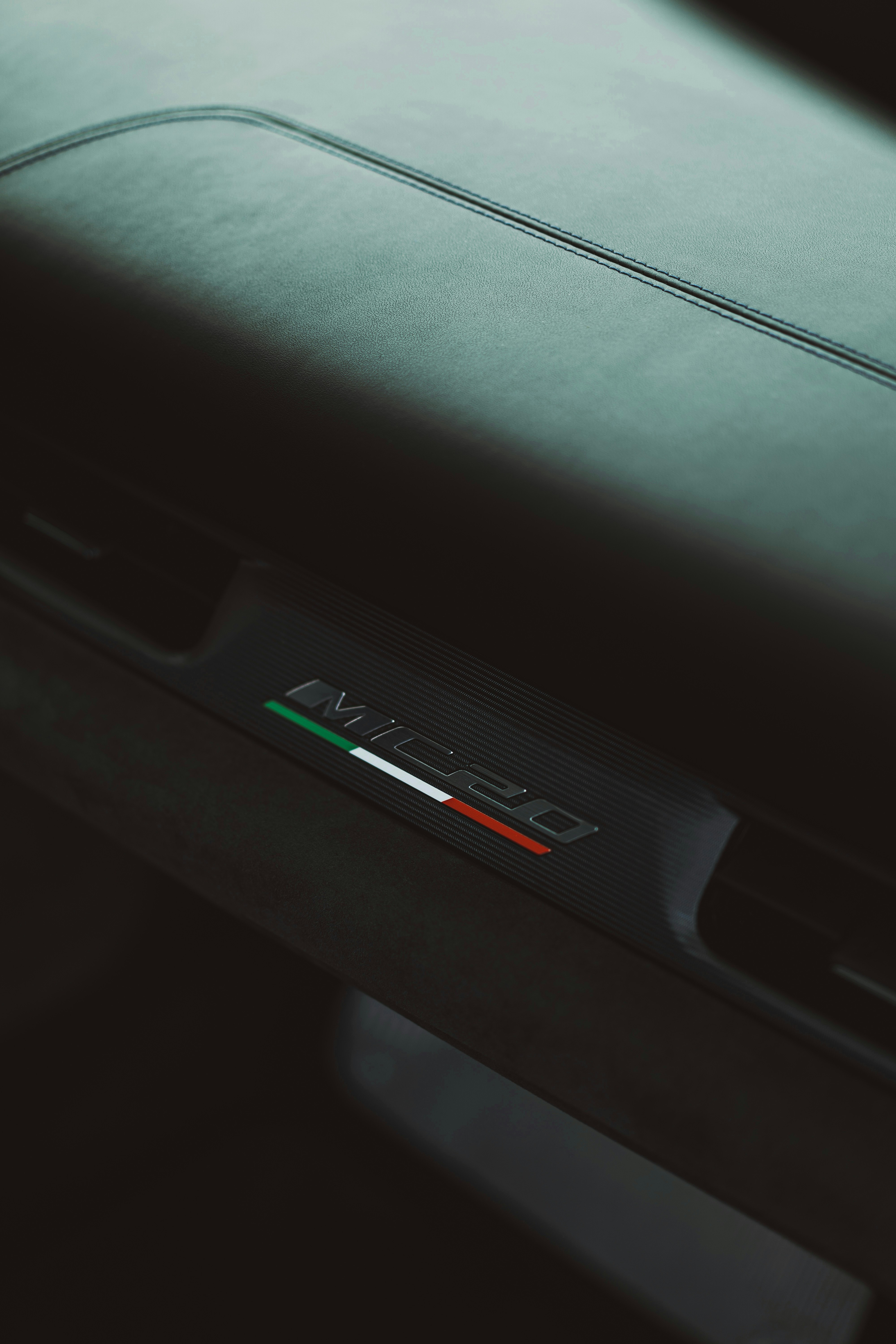 Close-up of a car's interior with italian flag emblem.