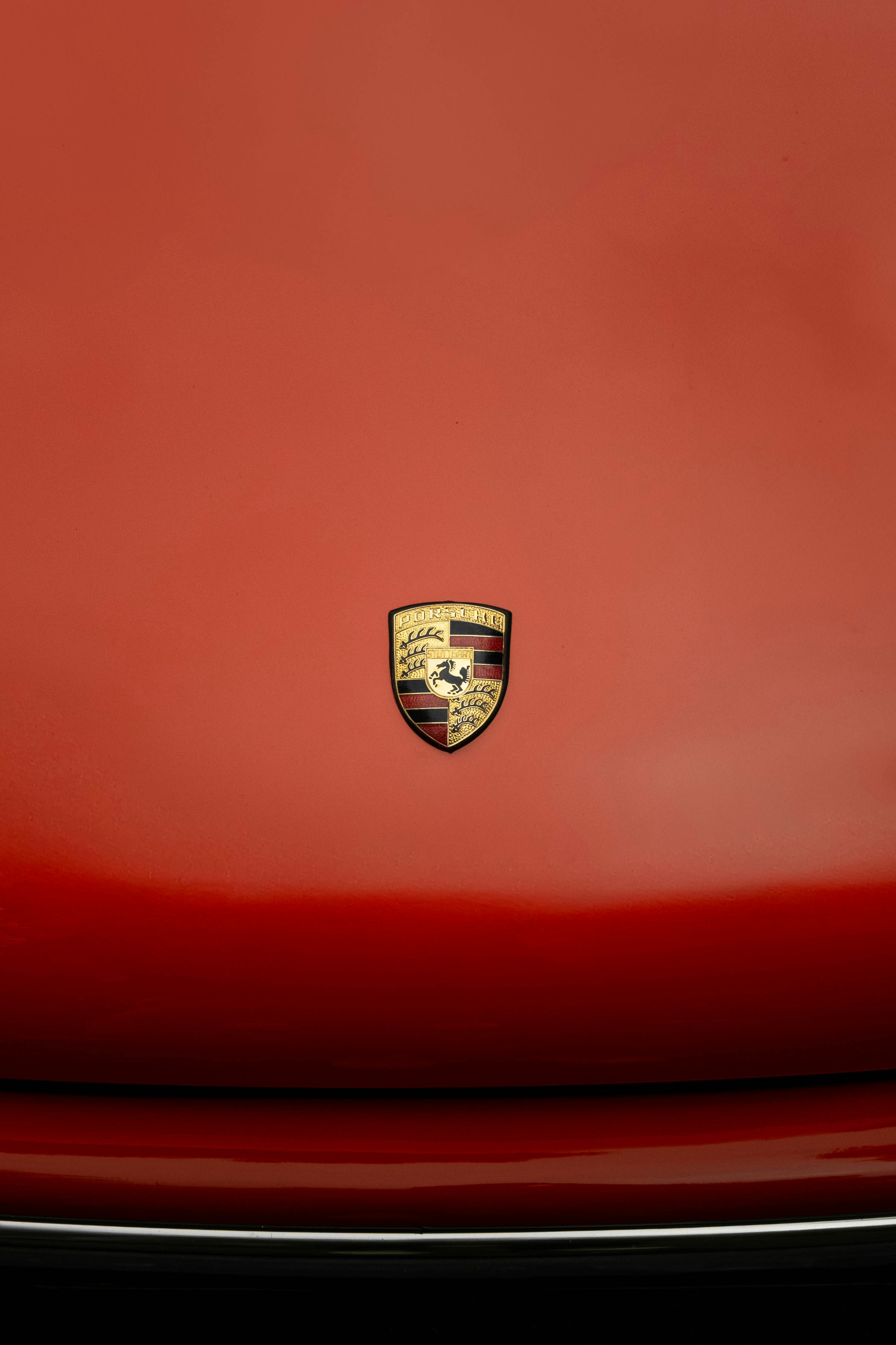 Red porsche emblem on a car hood photo – Free Car Image on Unsplash