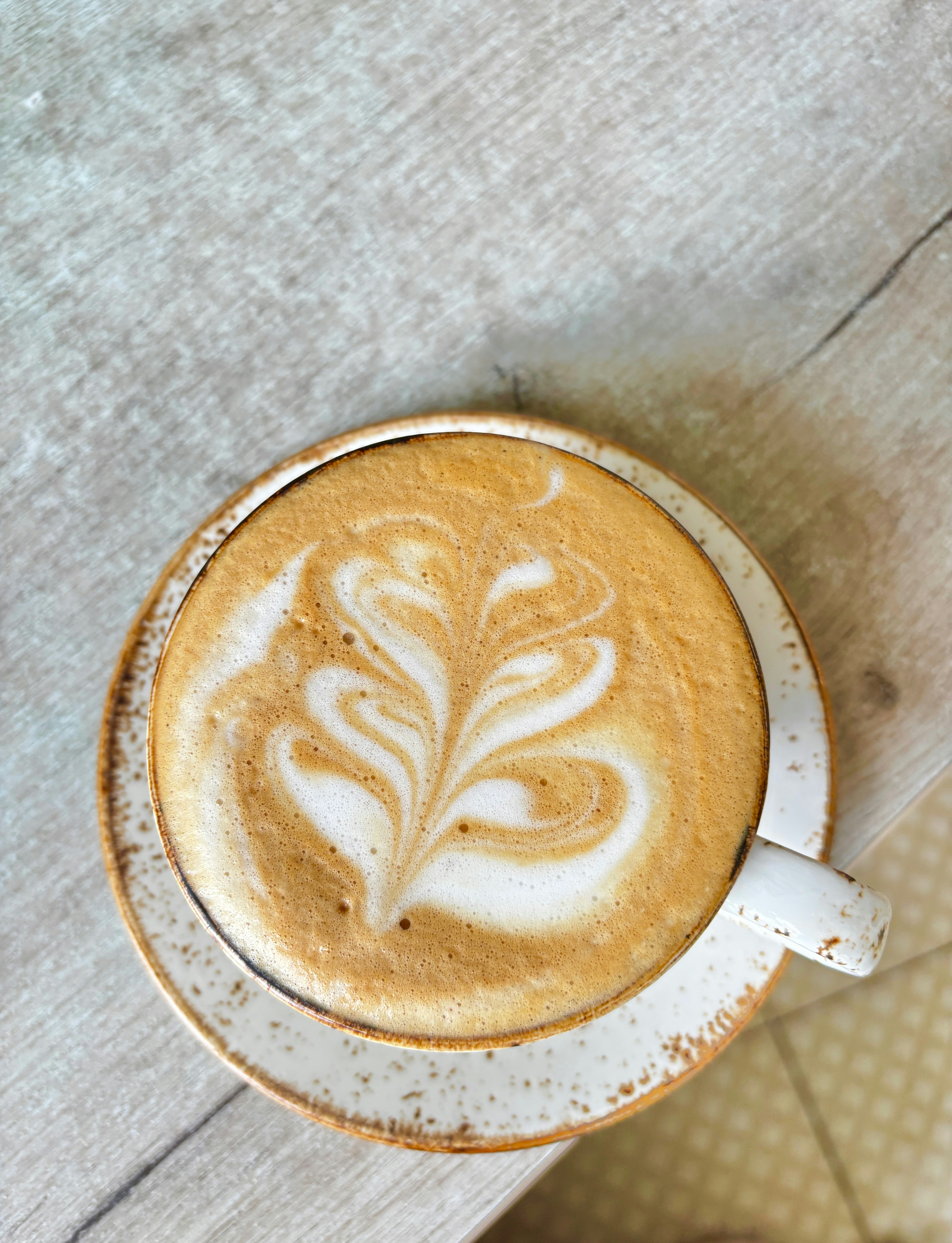 A cup of coffee with latte art on a saucer.