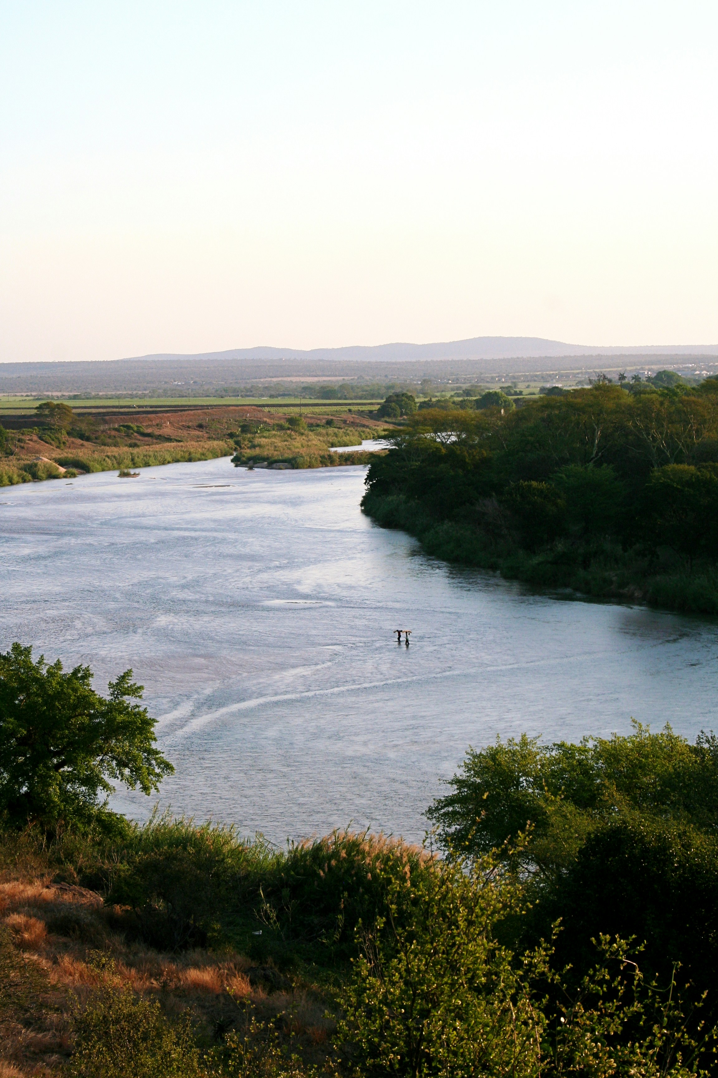 Wide river flowing through a lush green landscape