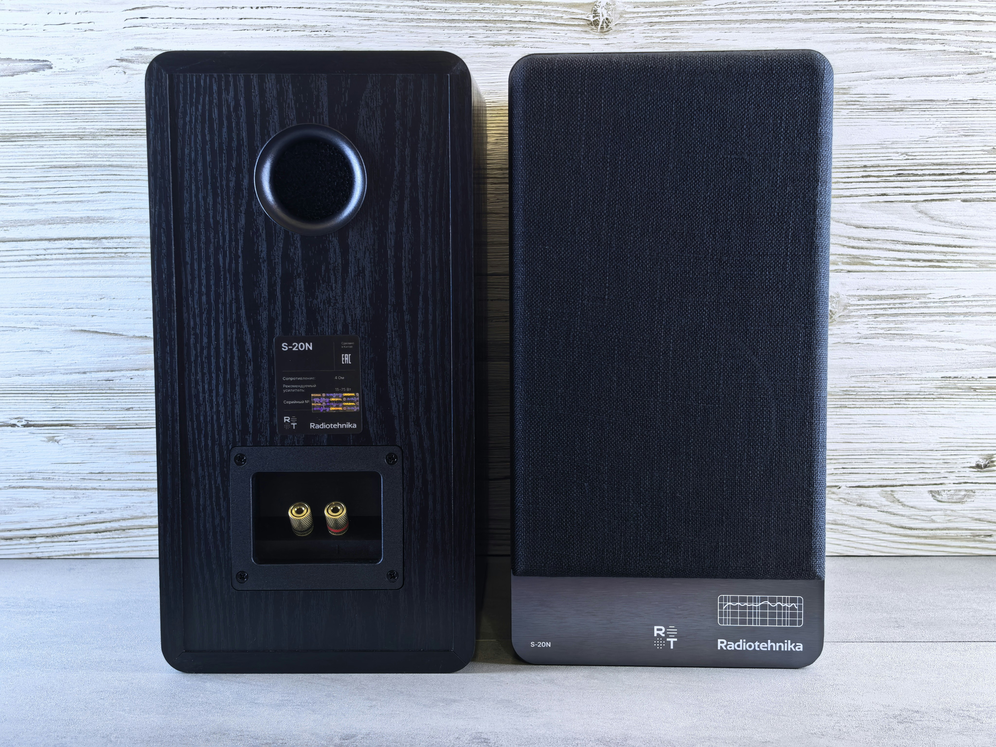 Two black speakers shown from the back and front.