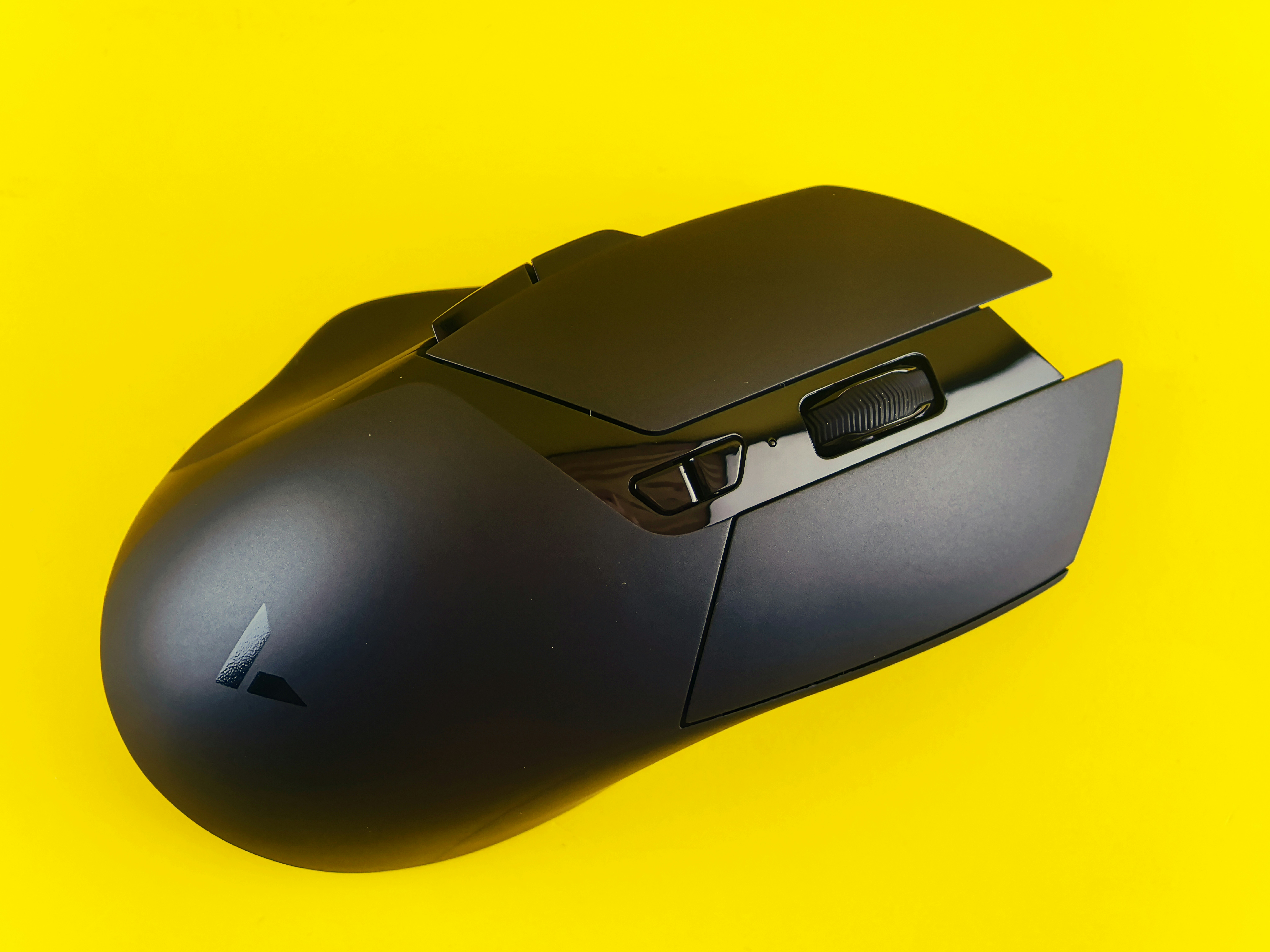 Black computer mouse on a bright yellow background