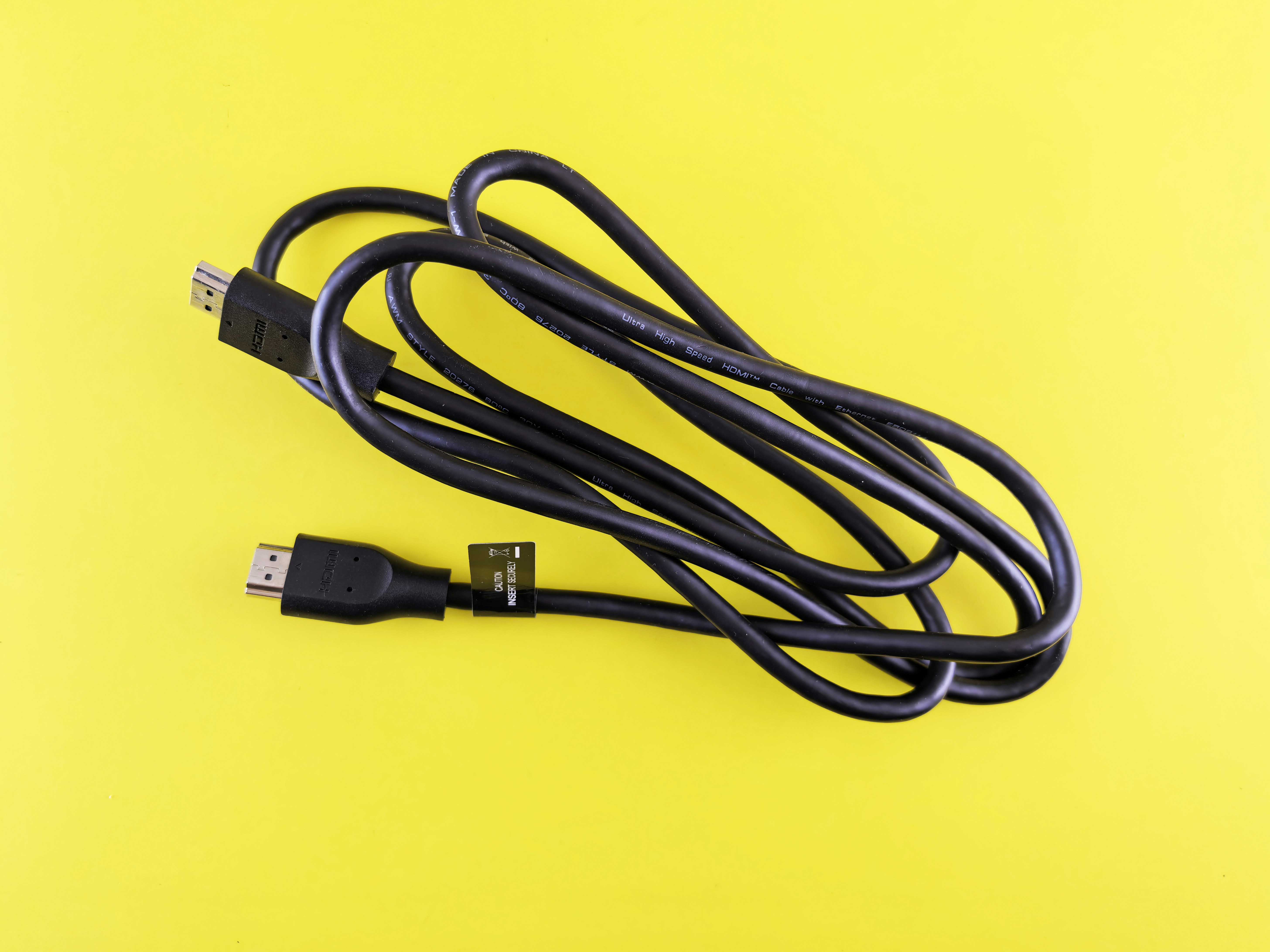 Black usb cable on a bright yellow background