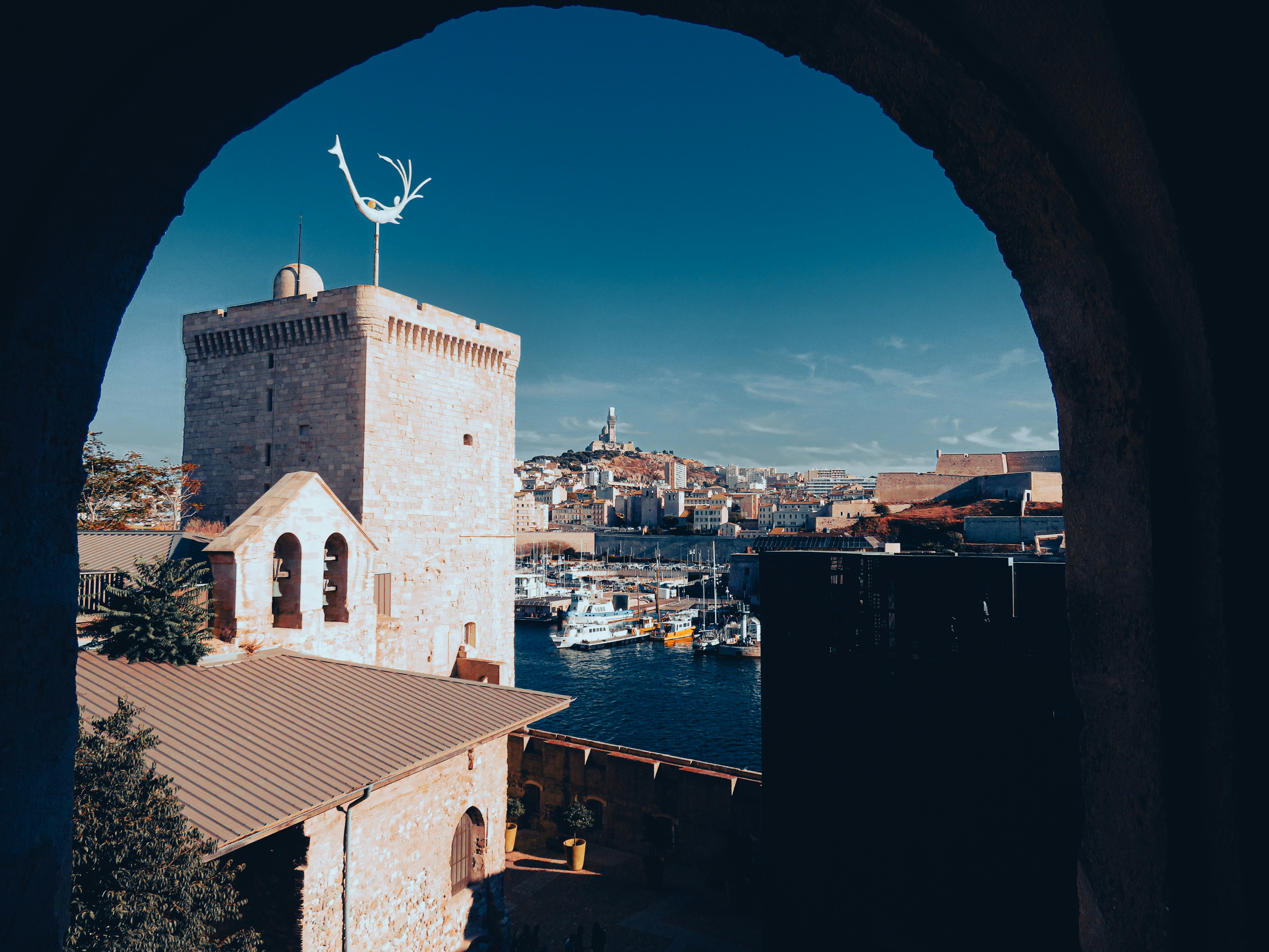 Historic tower overlooking a harbor with sailboats