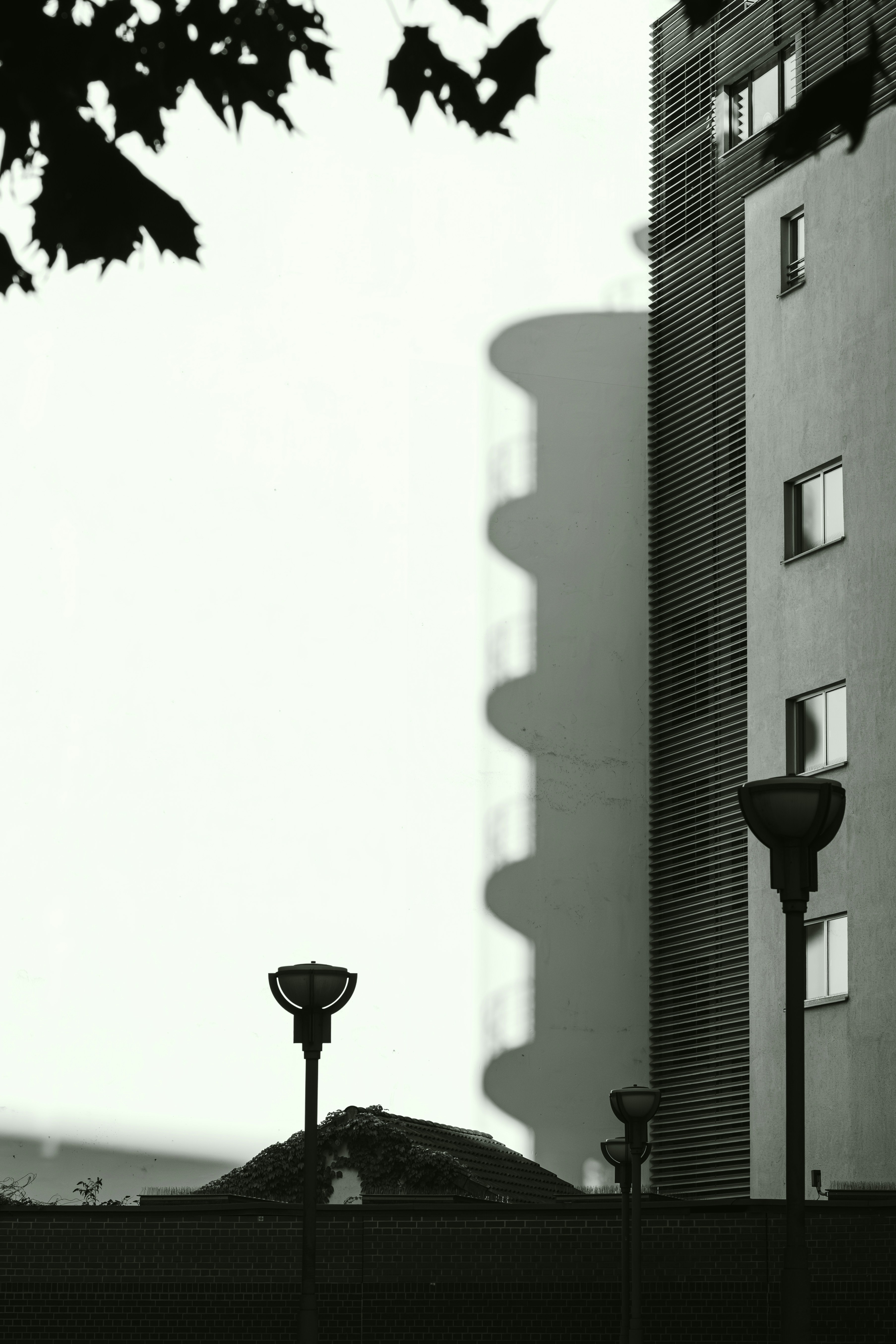 Modern building with curved shadow and streetlights
