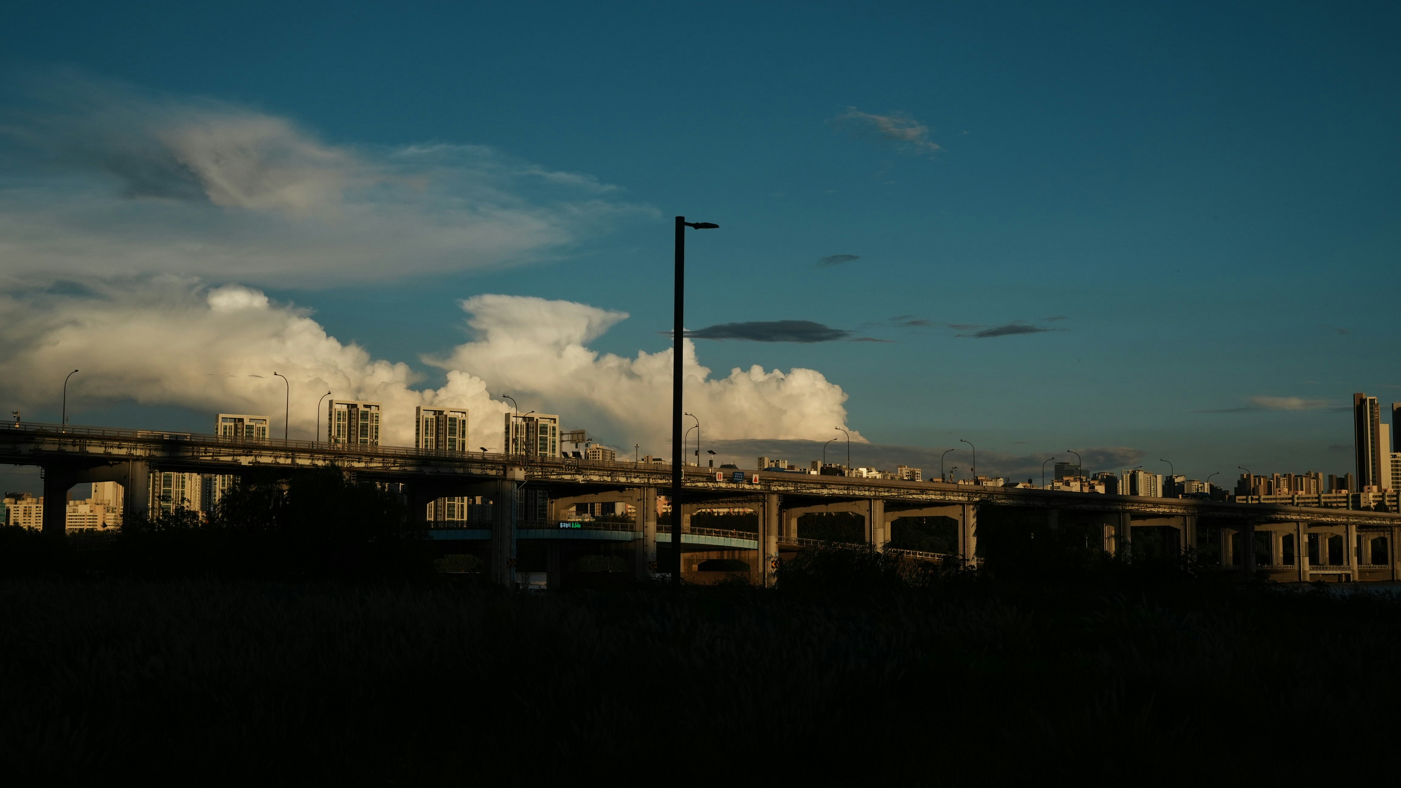 Cityscape with highway overpass and dramatic clouds