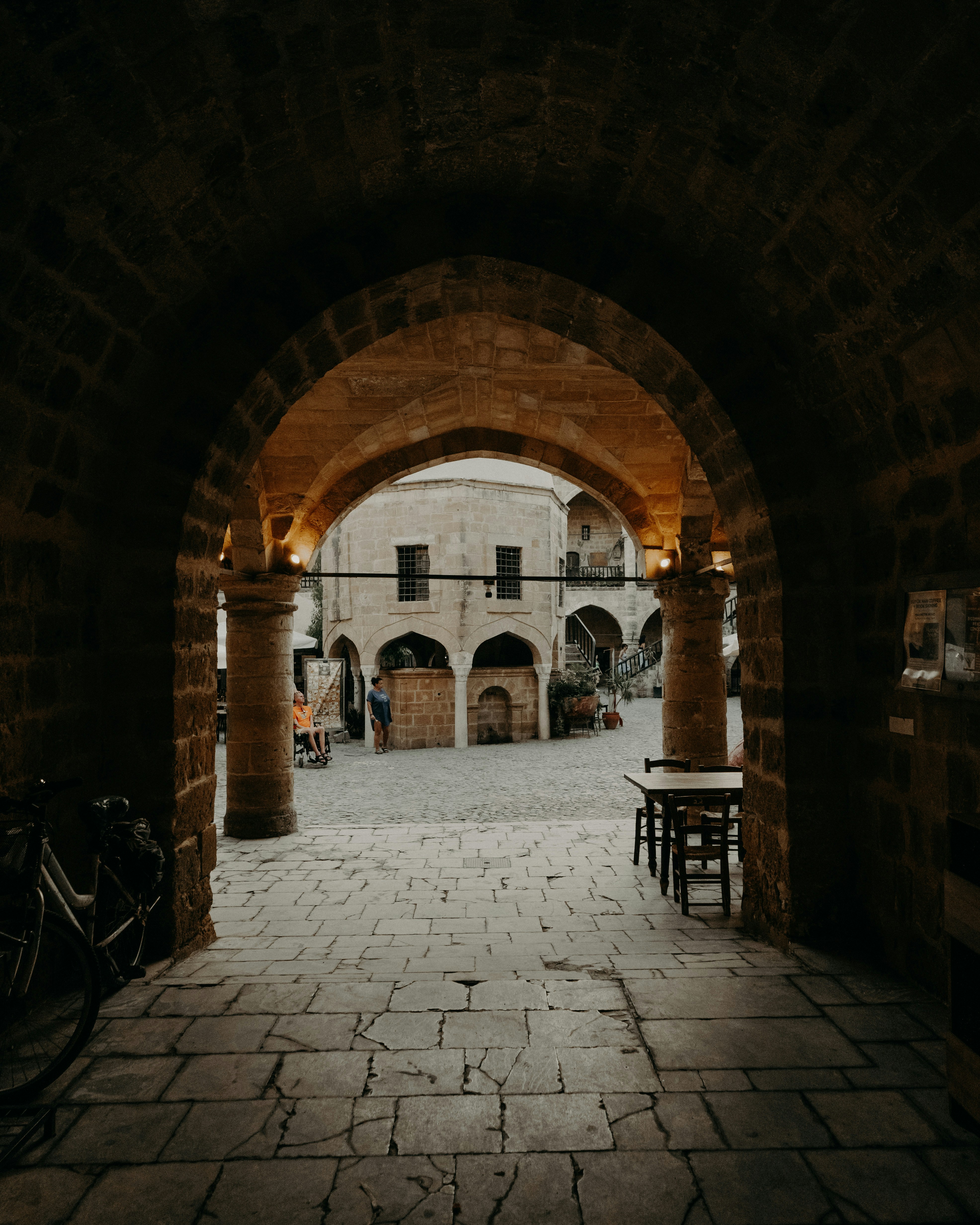 Stone archway leading to a courtyard with buildings. photo – Free Dark ...