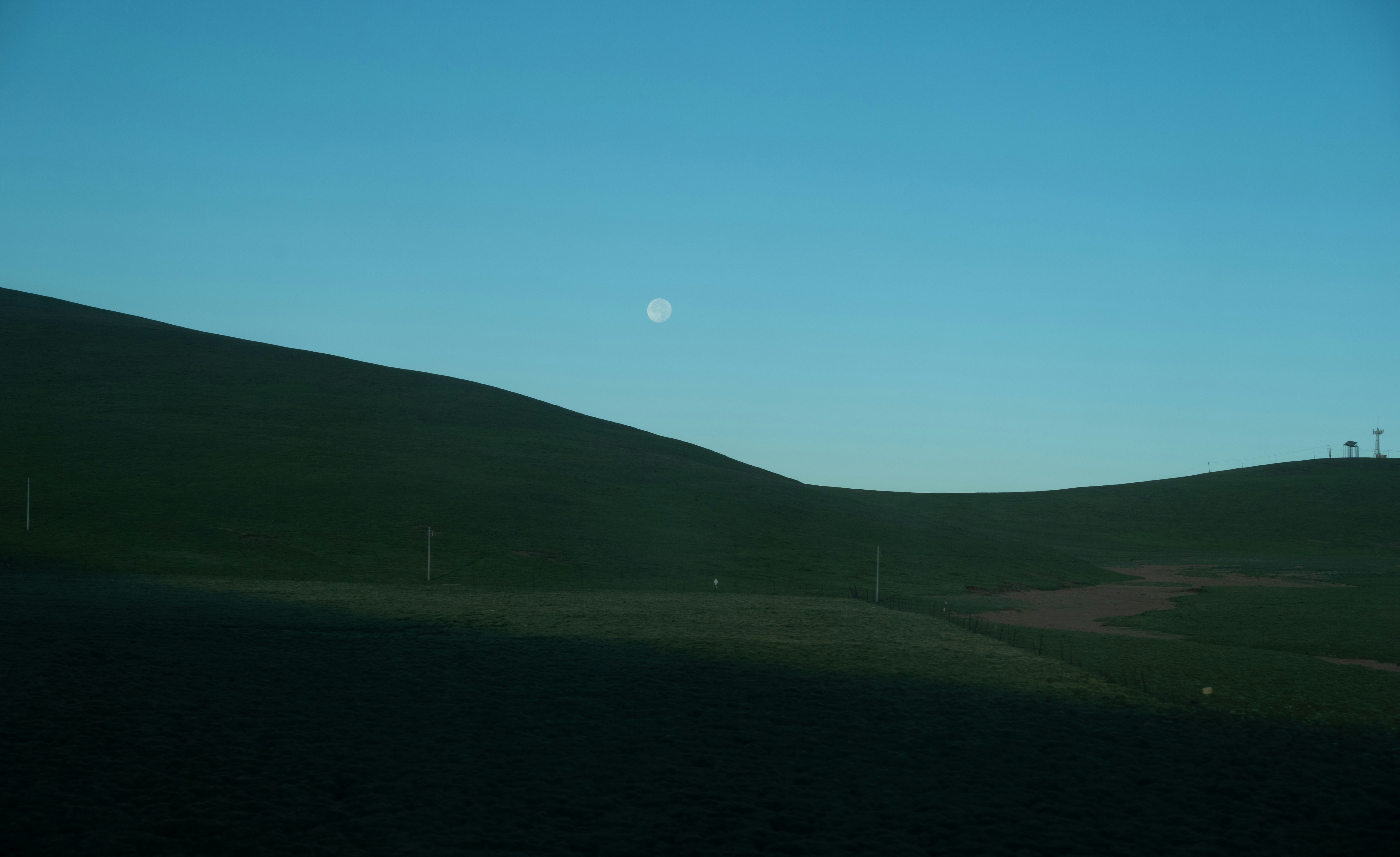 Lunar Serenade Over Rolling Hills