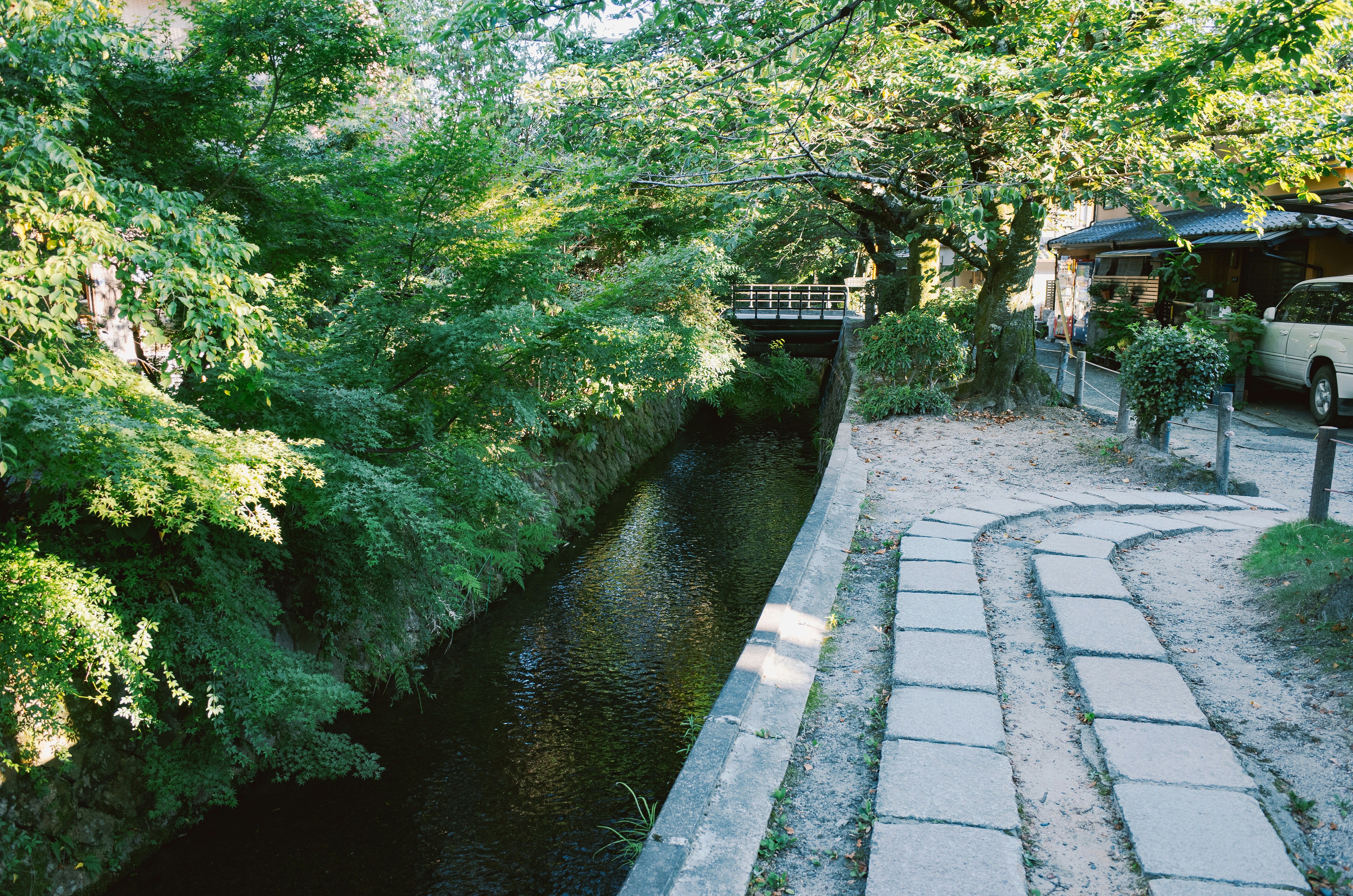 A canal with a stone path and trees