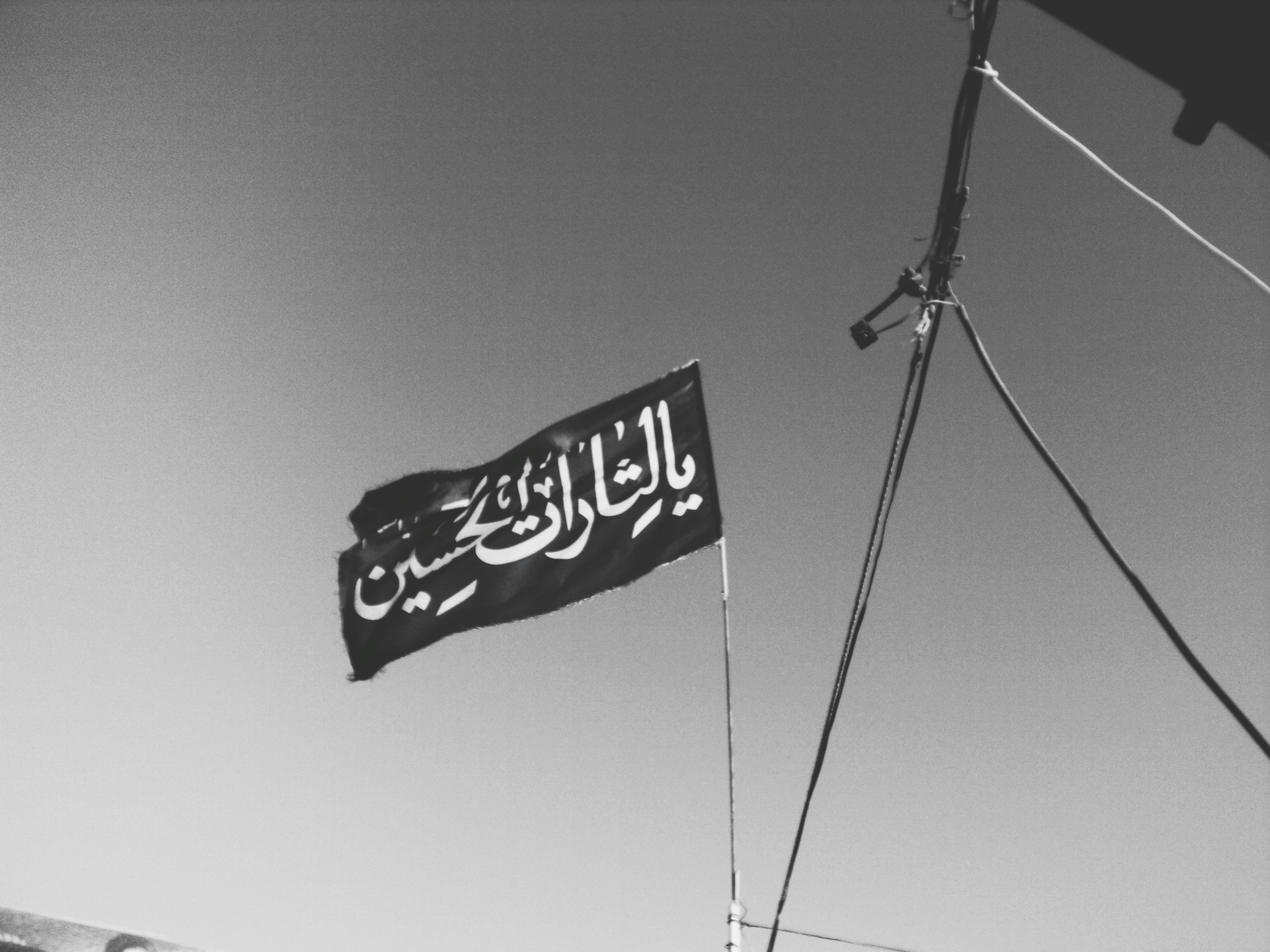 The beautiful poetry of a timeless symbol. | Black flag with arabic script waves against sky