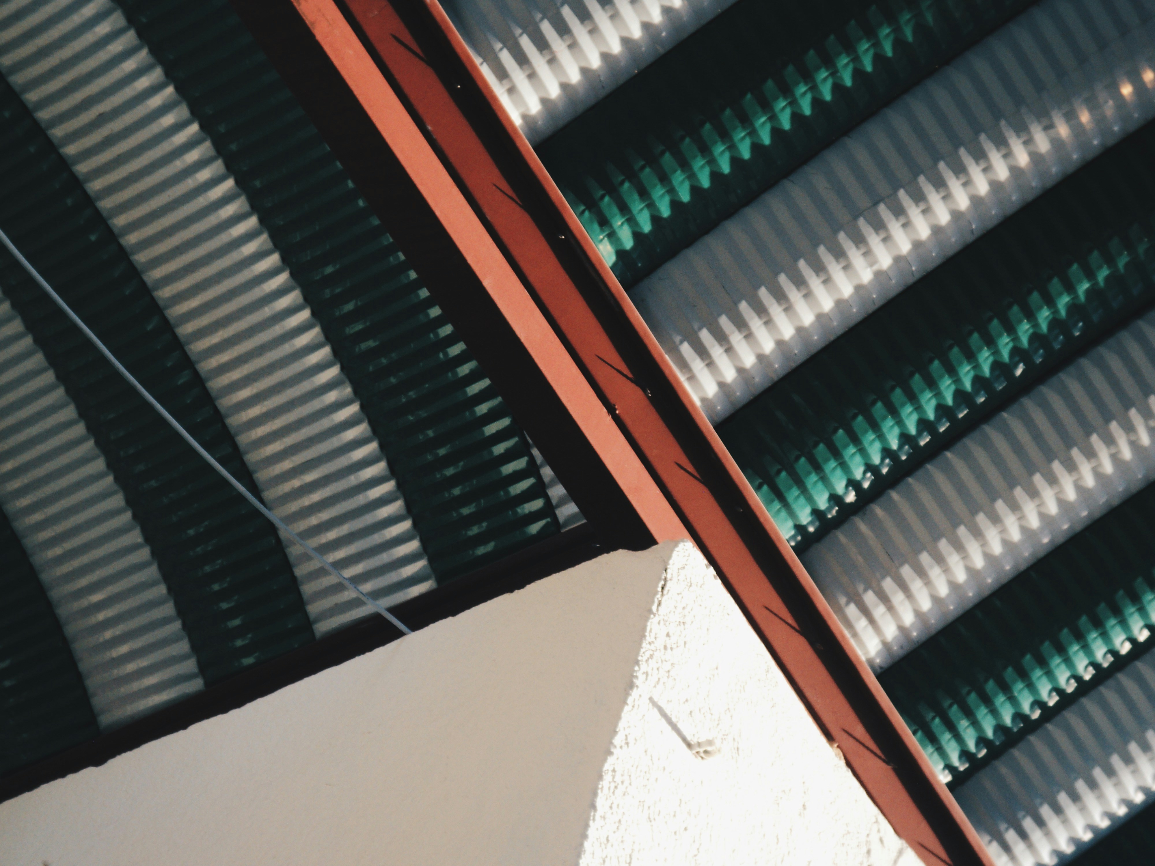 A portrait of a moment, still and calm. | Corrugated metal roof with white structure.