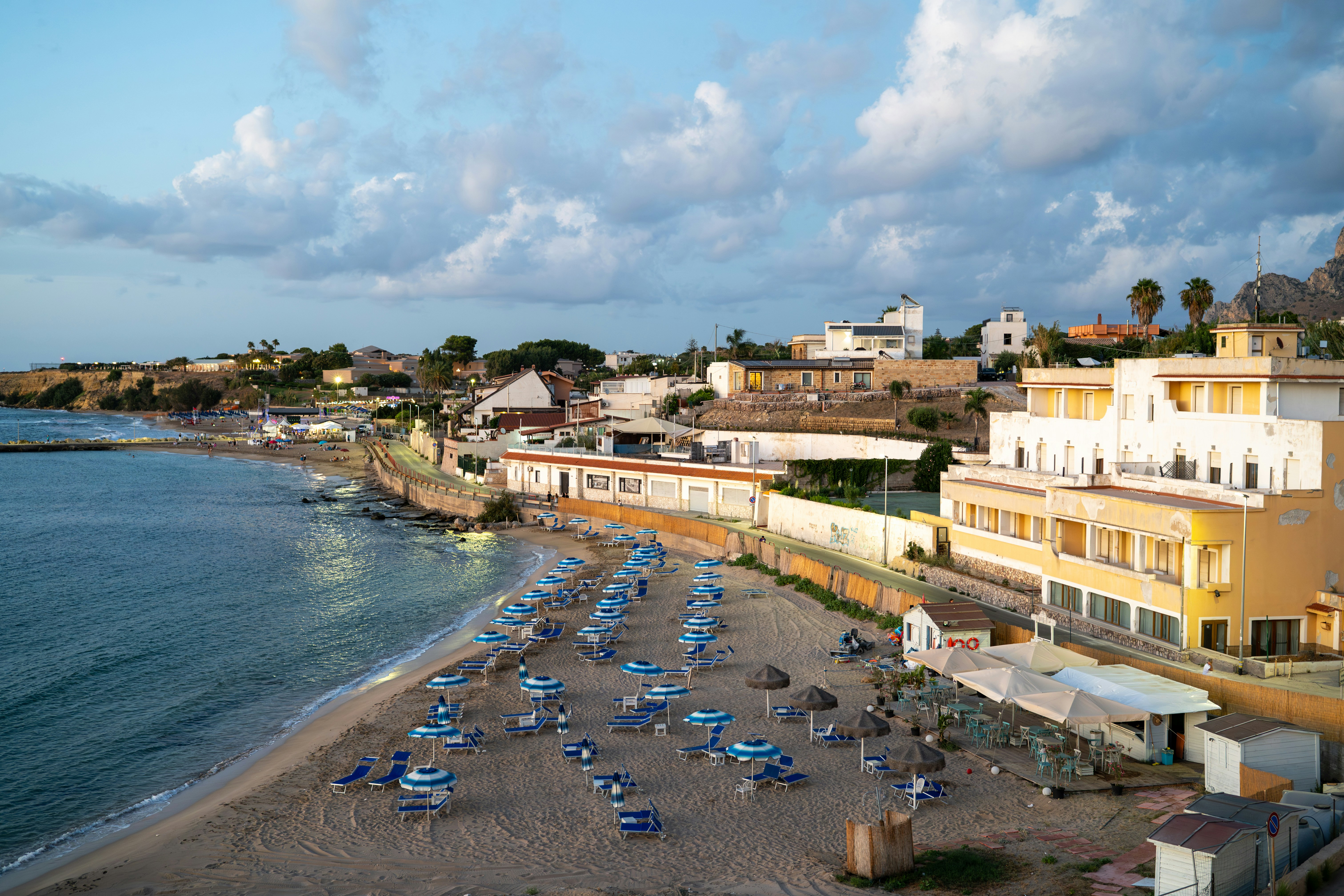 Azure Umbrella Grid Over a Sunlit Mediterranean Beachfront