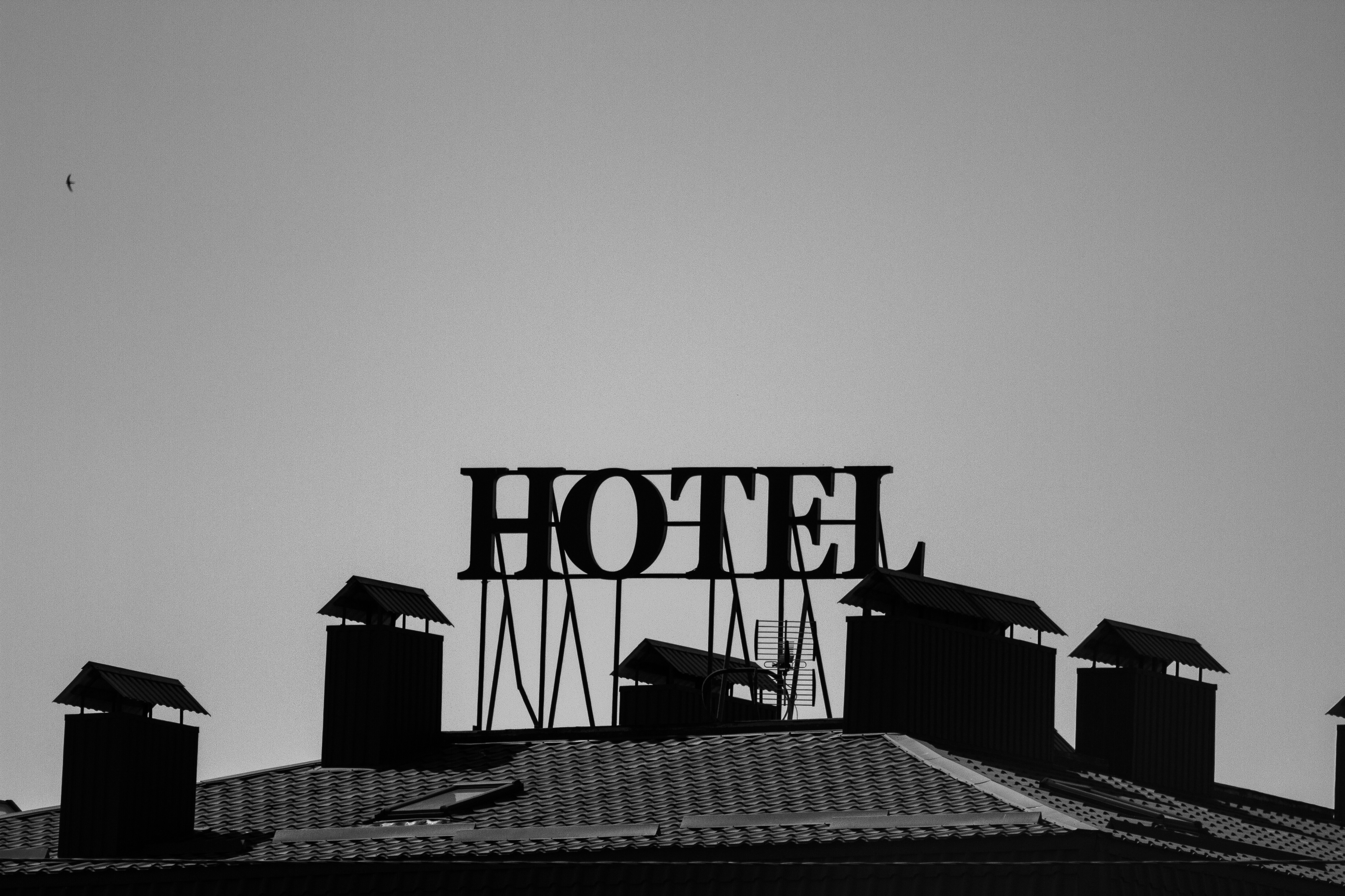 Hotel sign on a rooftop with chimneys