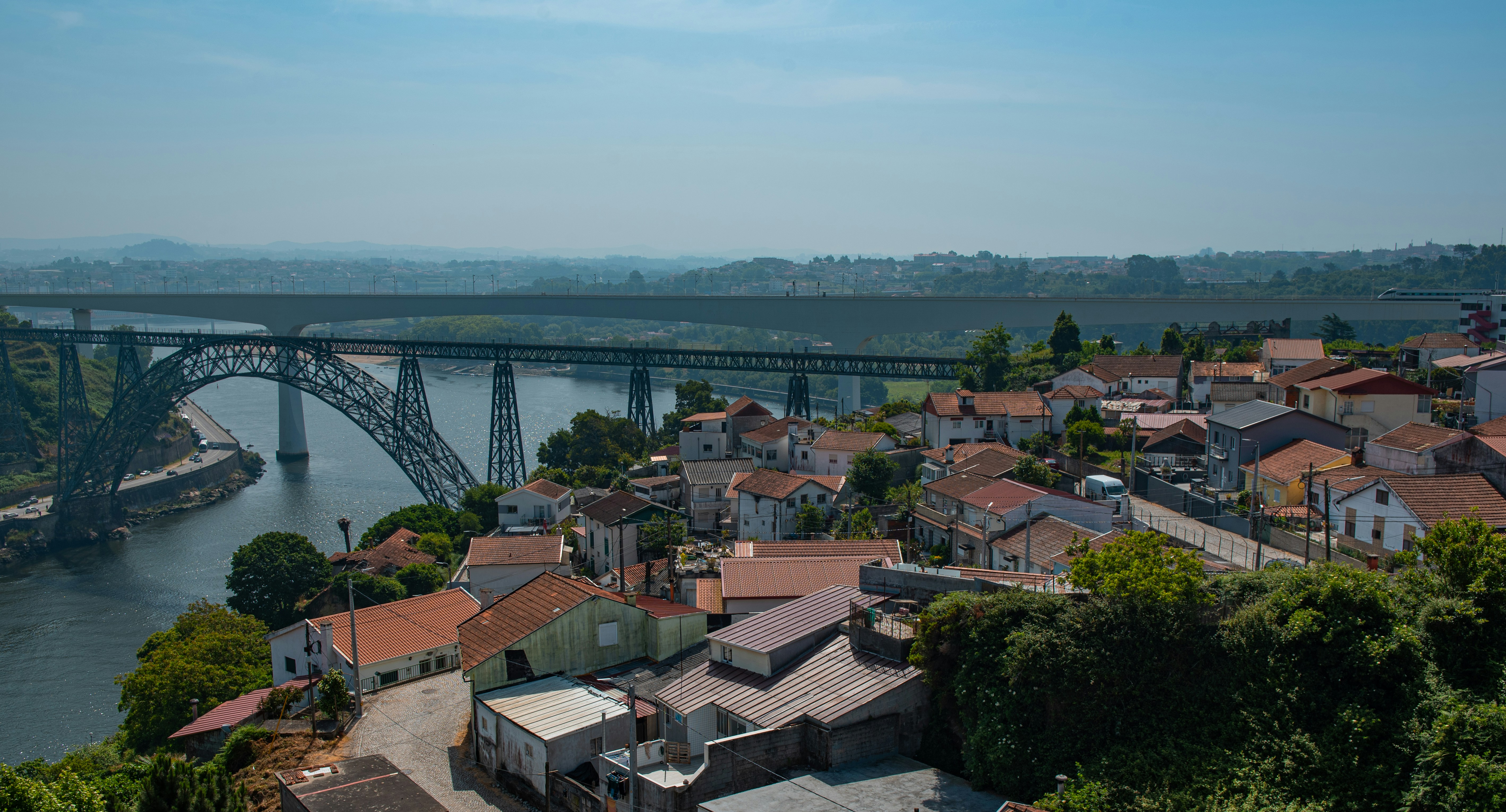 Bridge at Dawn Over a Terracotta City: An Aerial Study of Steel Lines and Red Tile Roofs