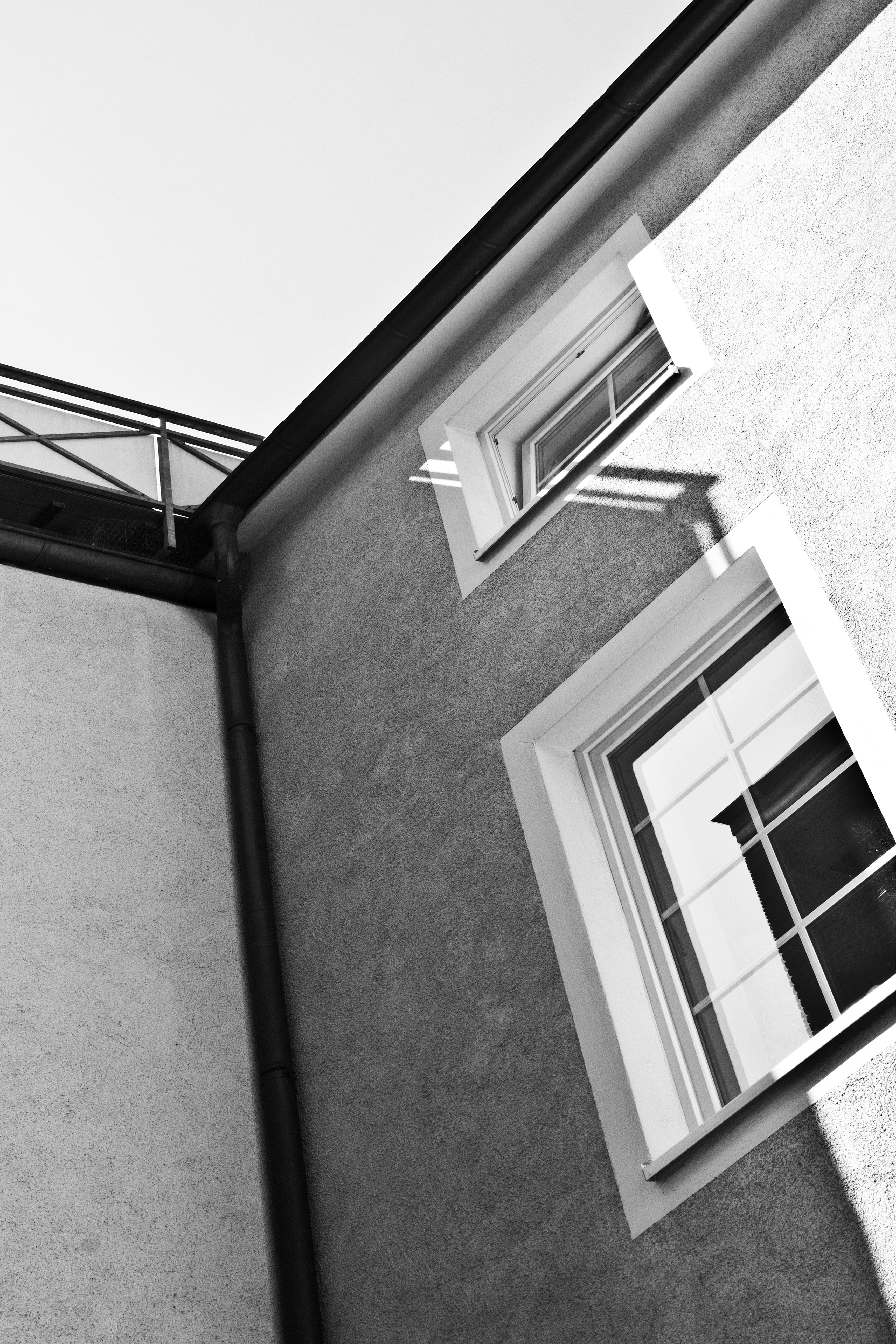 Architectural details of a building corner with contrasting textures and light play in black and white.